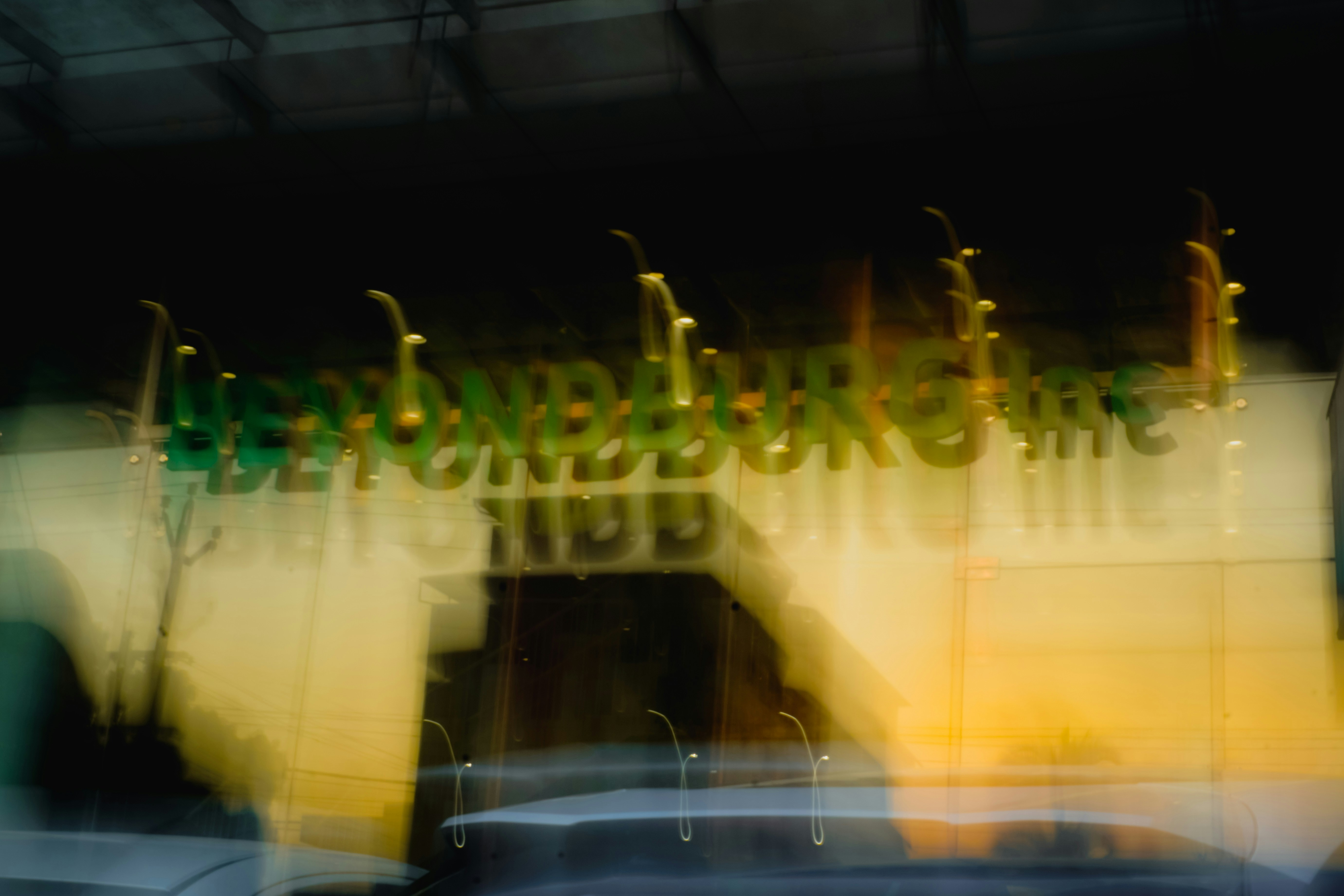 Glowing Sign Blur Through Transit Windows at Dusk
