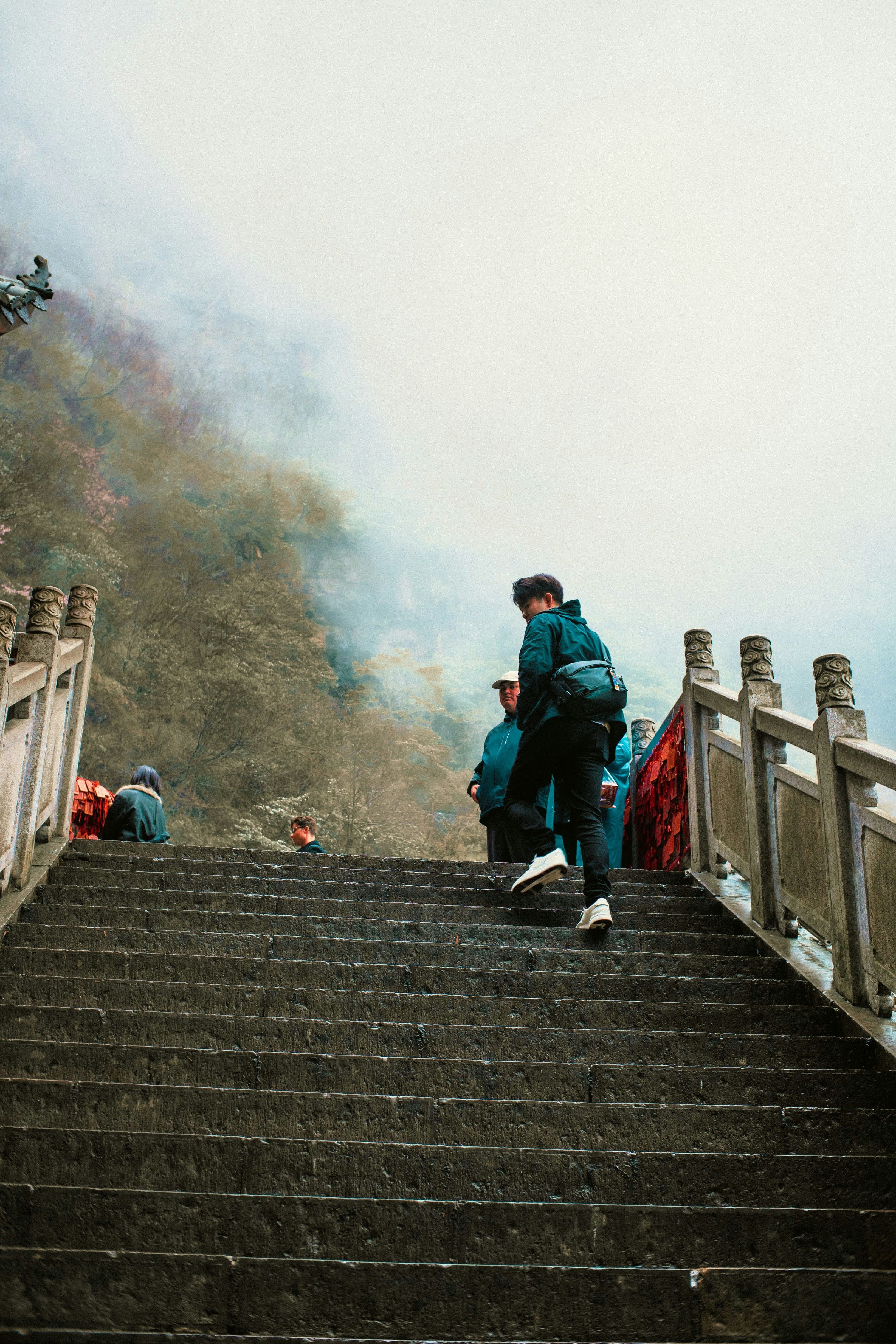 Stairway to Mist: Travelers Pause on a Mountain Path