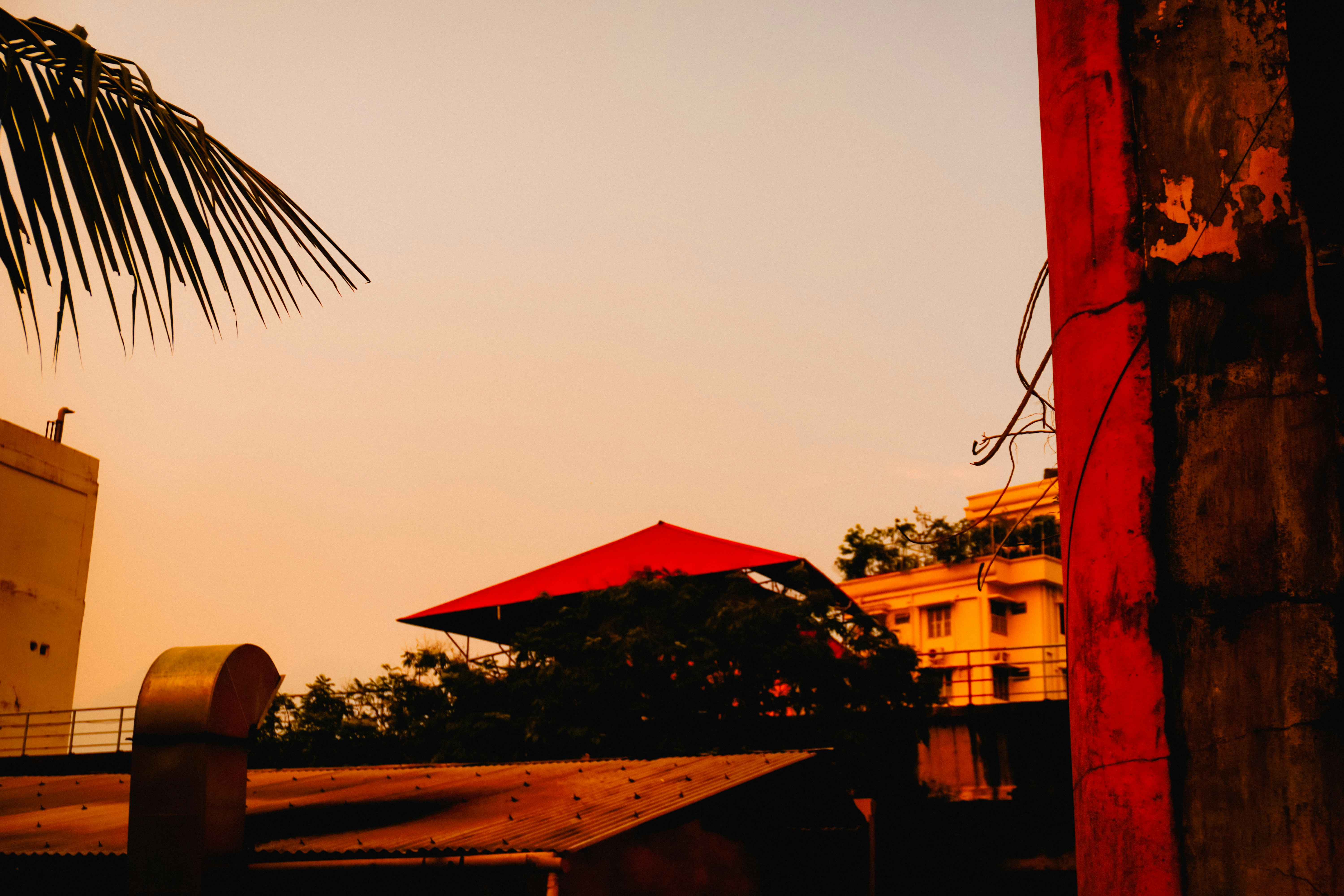 Amber Rooftops at Dusk with Red Umbrella Canopy