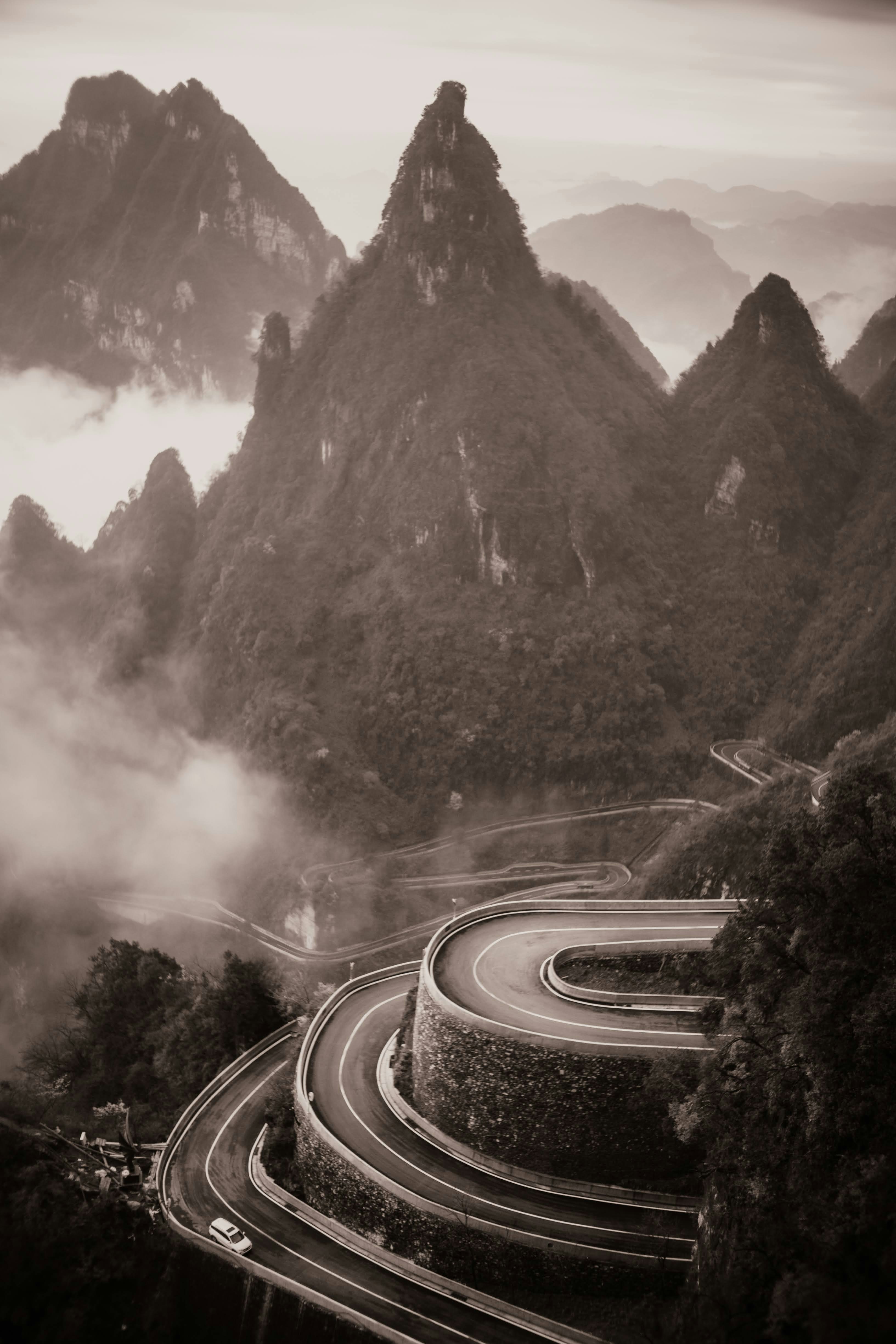 Serpentine Summit: A Mountain Road Winding Through Mist
