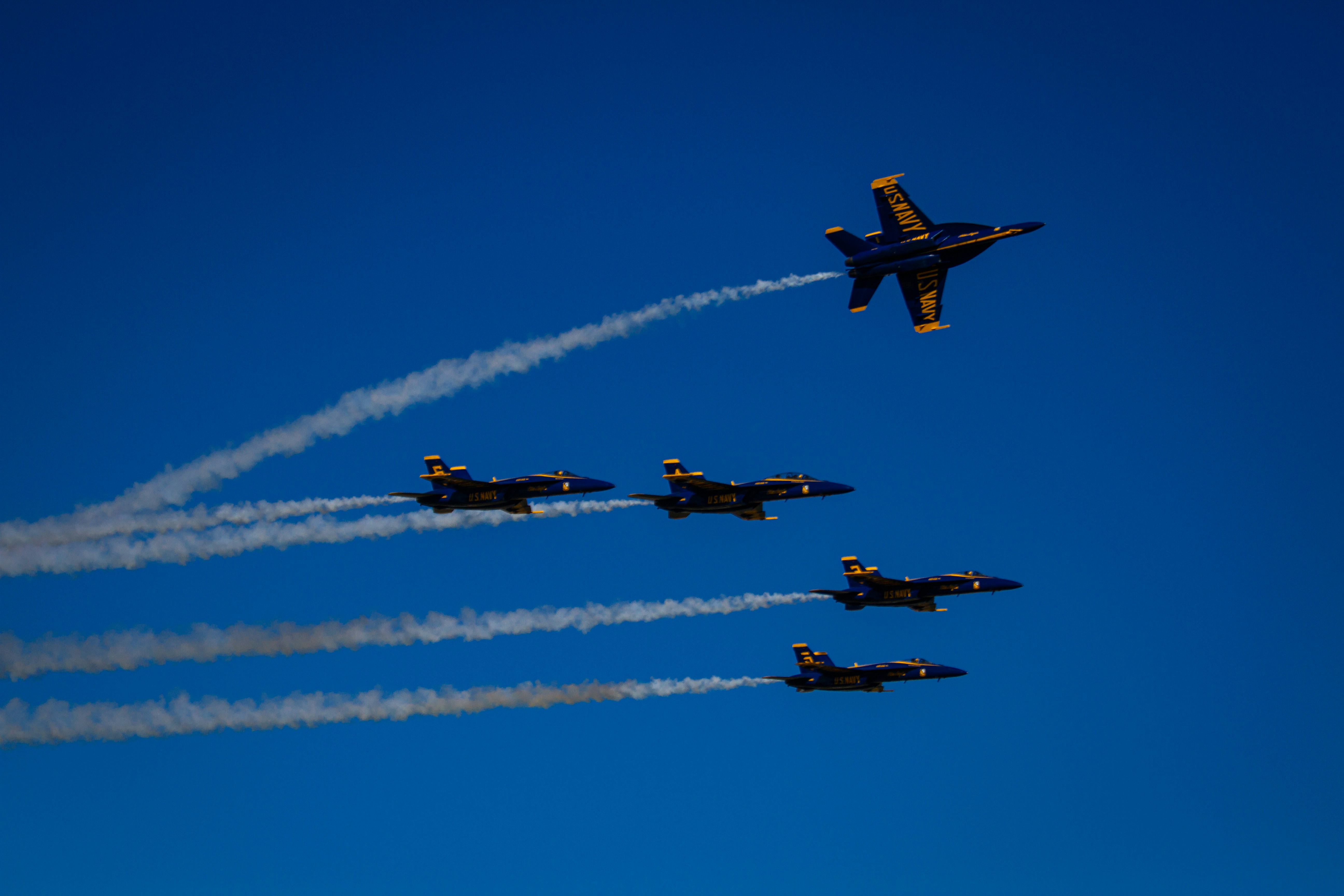 Aerial Mosaic: Five Jets Carve White Trails Across a Bold Blue Sky