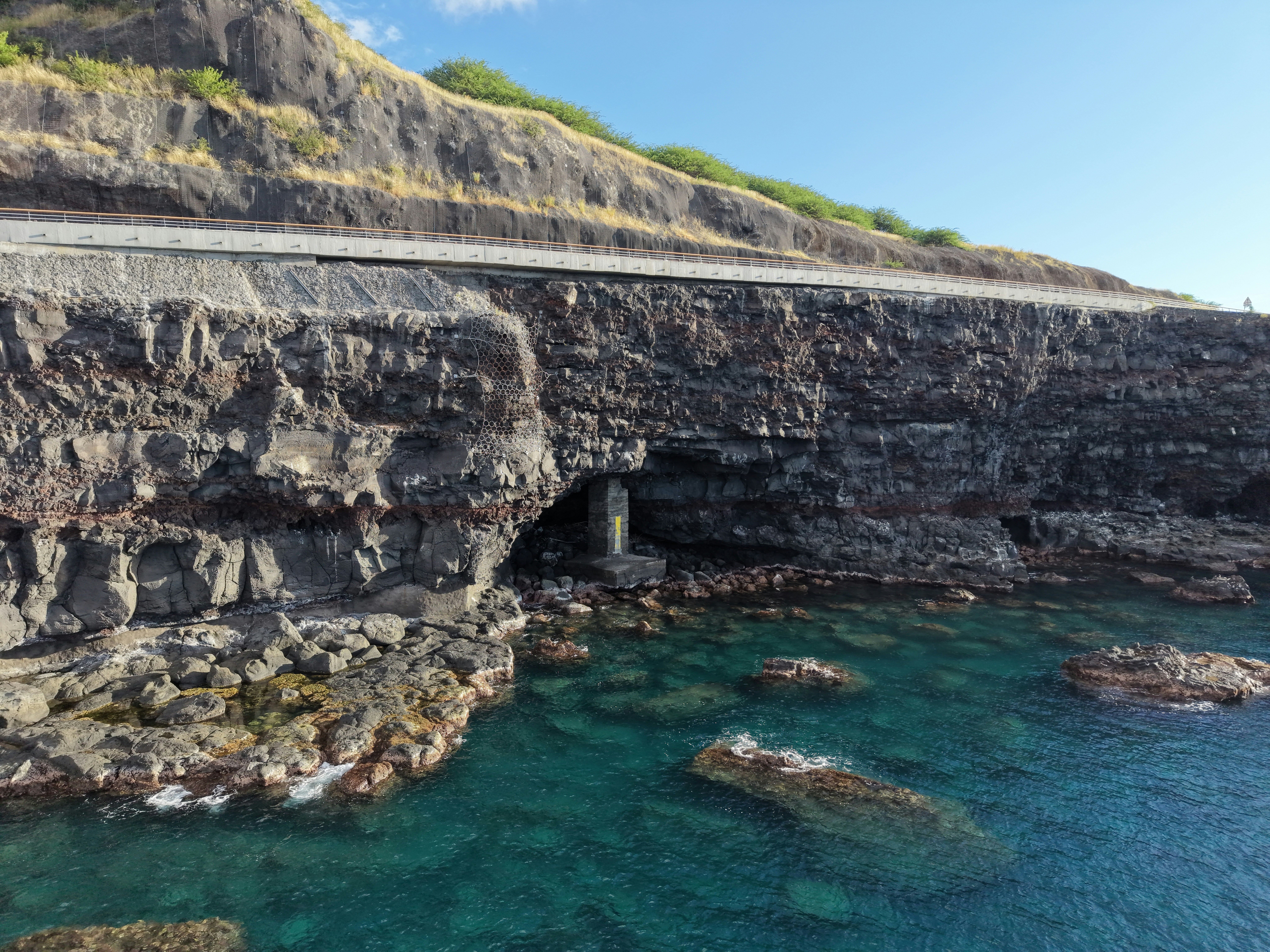 Coastal Cliff Overlook: Sunlit Rocks and Turquoise Waters