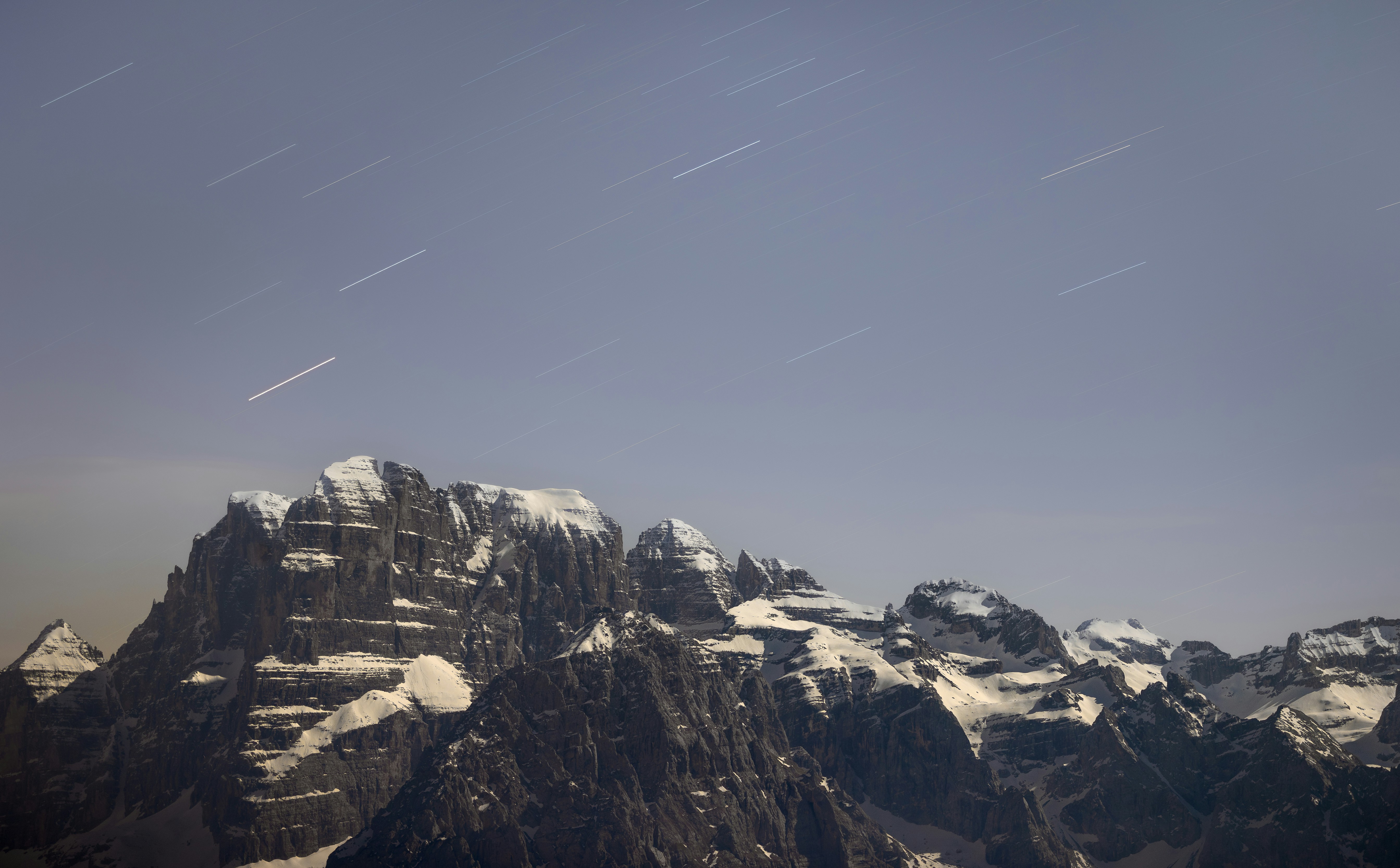 Snow-capped Peaks under a Starry Long-Exposure Sky