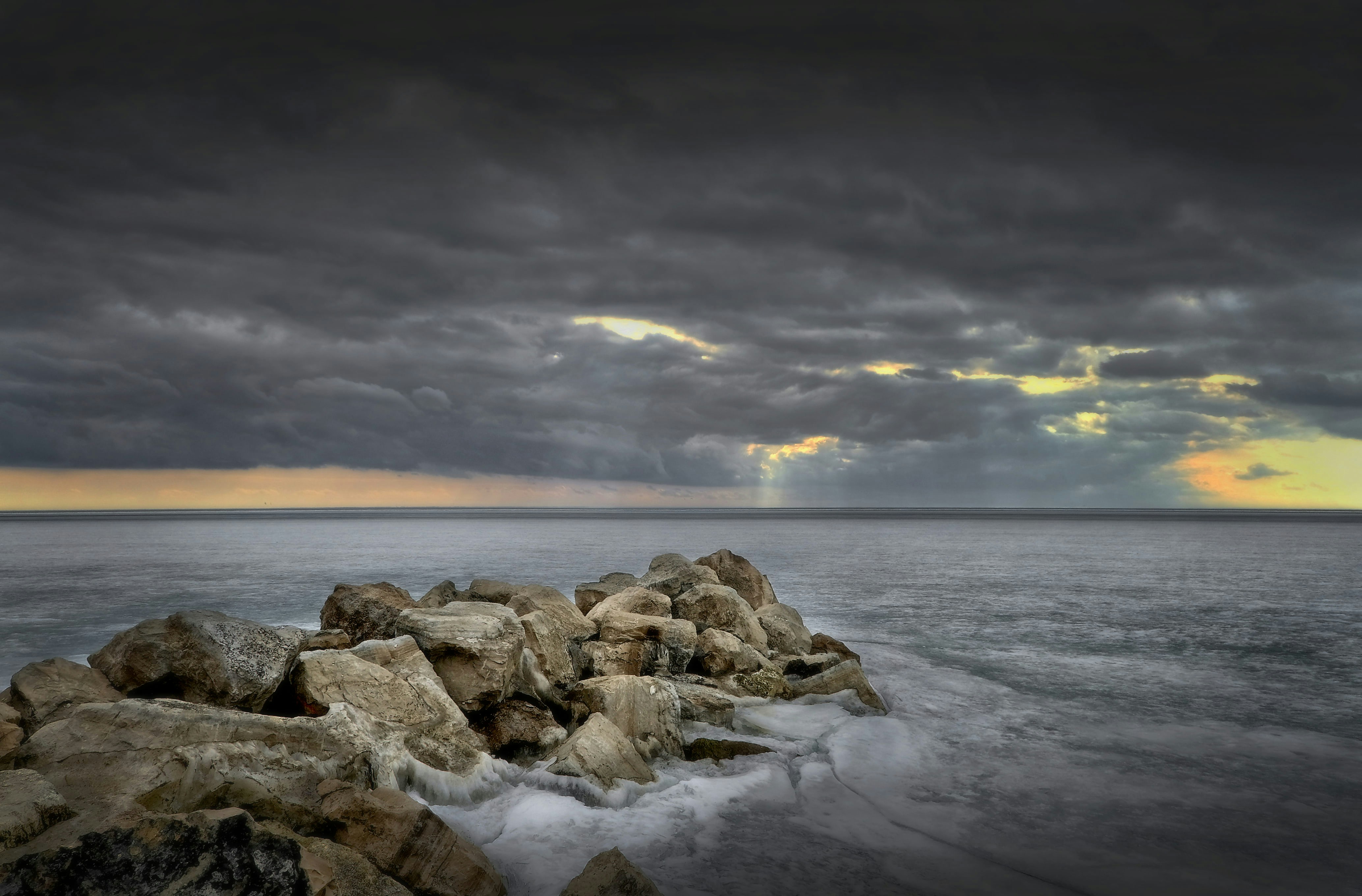Stormy Breakwater: Rugged Rocks Meet Quiet Horizon