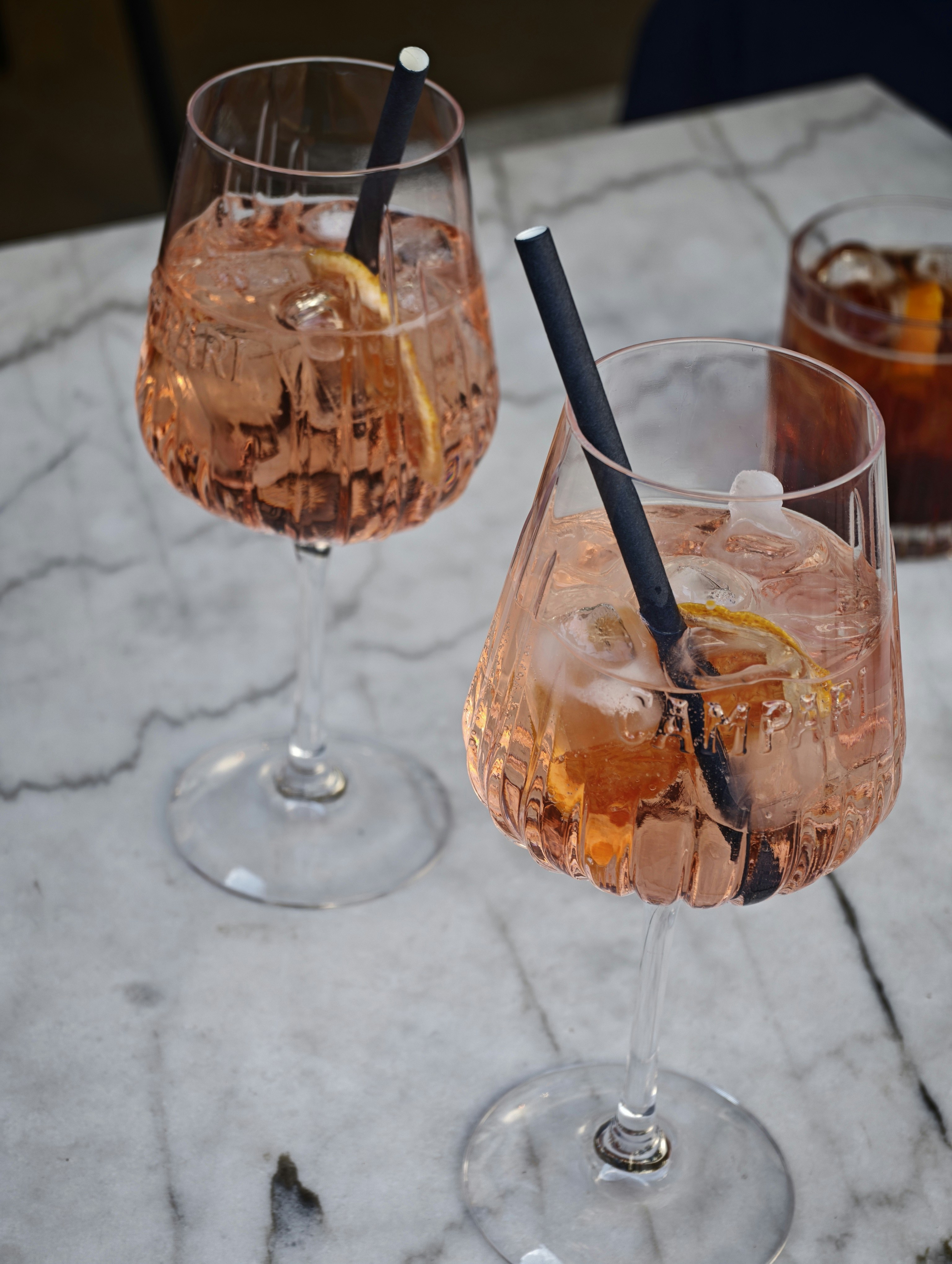 Orange-tinged Aperitif Trio on Marble Counter