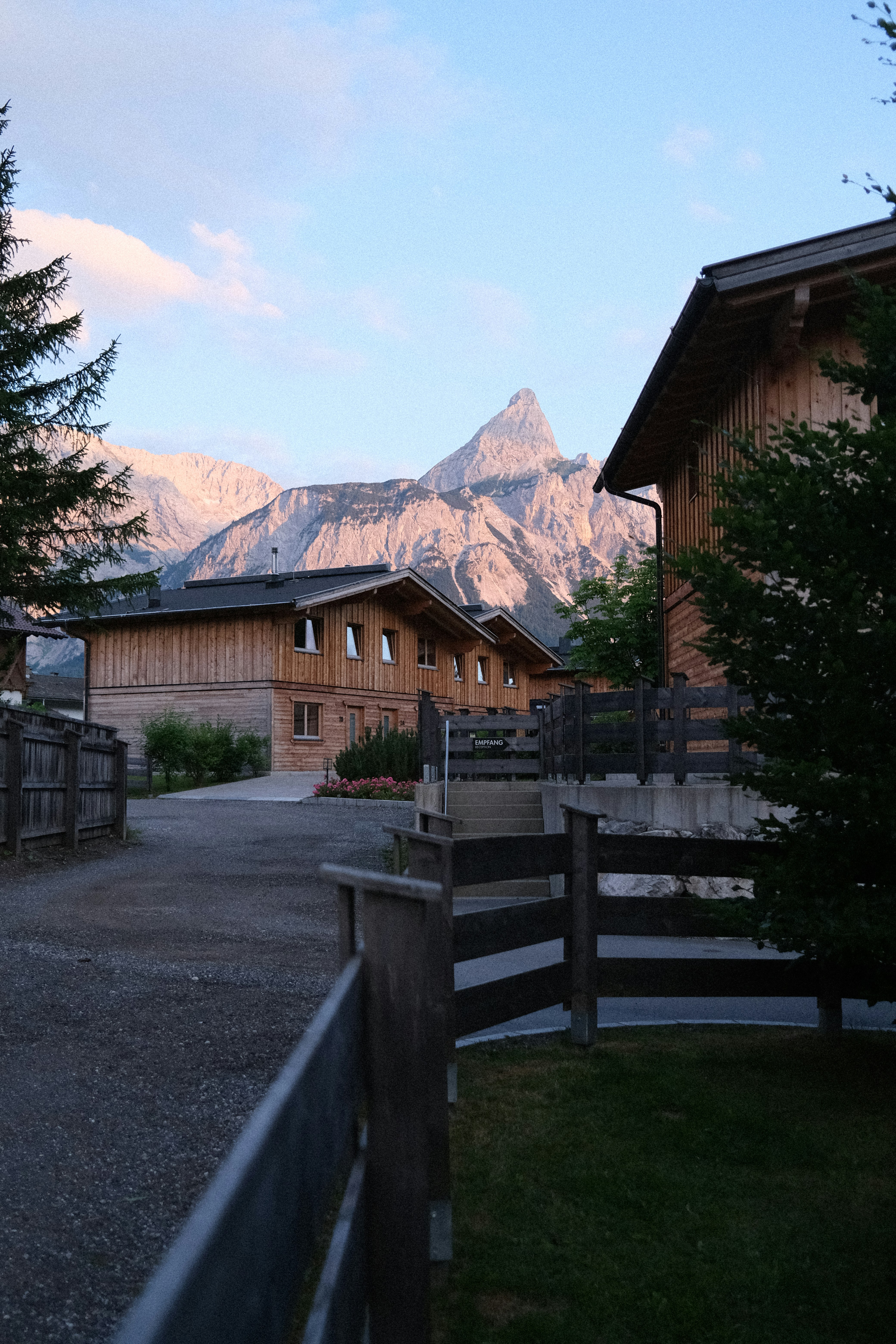 Mountain Village at Dusk: Wooden chalets Face the Peaks