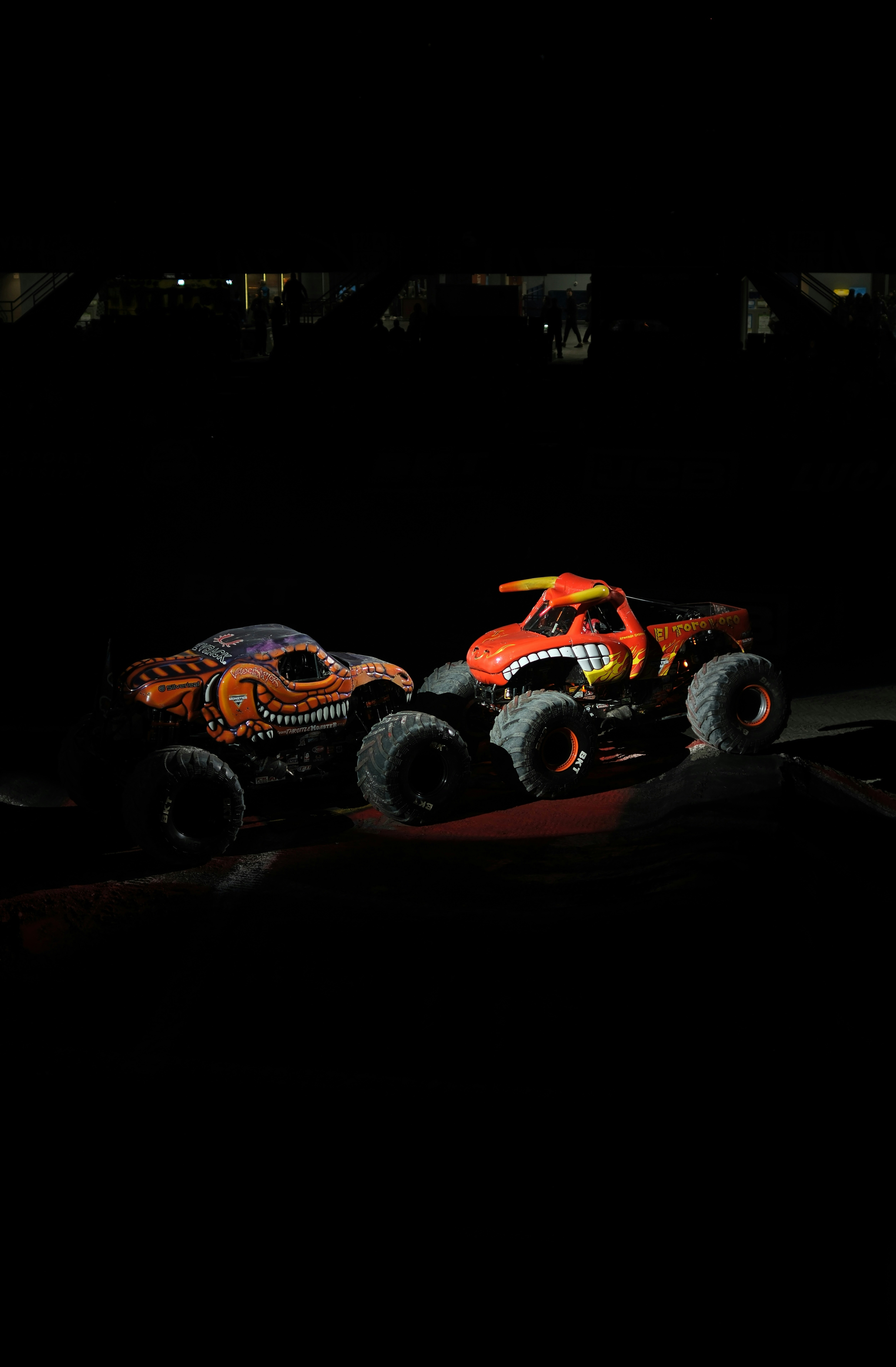 Nighttime Showdown: Twin Monster Trucks under the Arena Lights