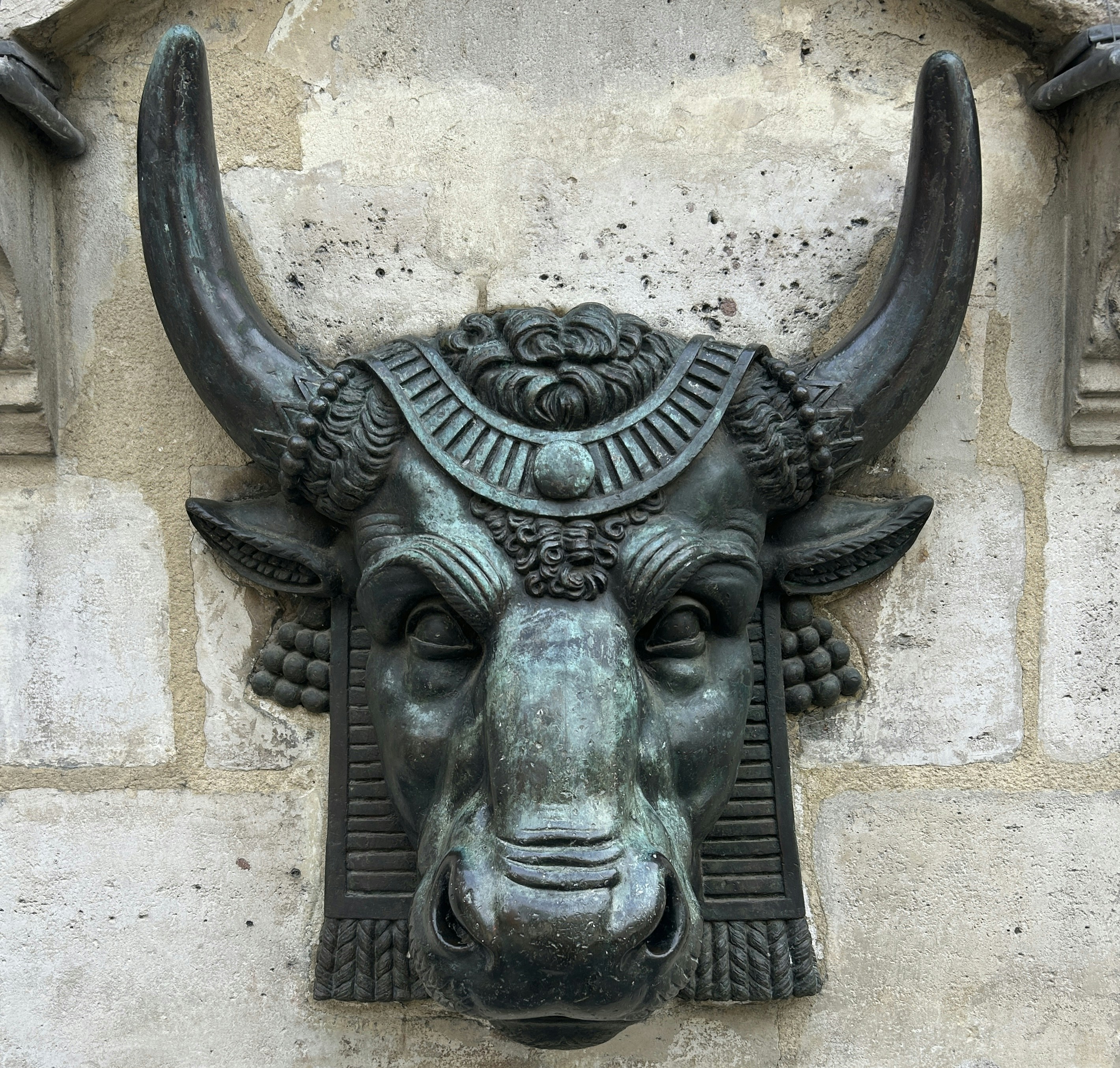 Bronze Bull Mask Adorning a Stone Facade