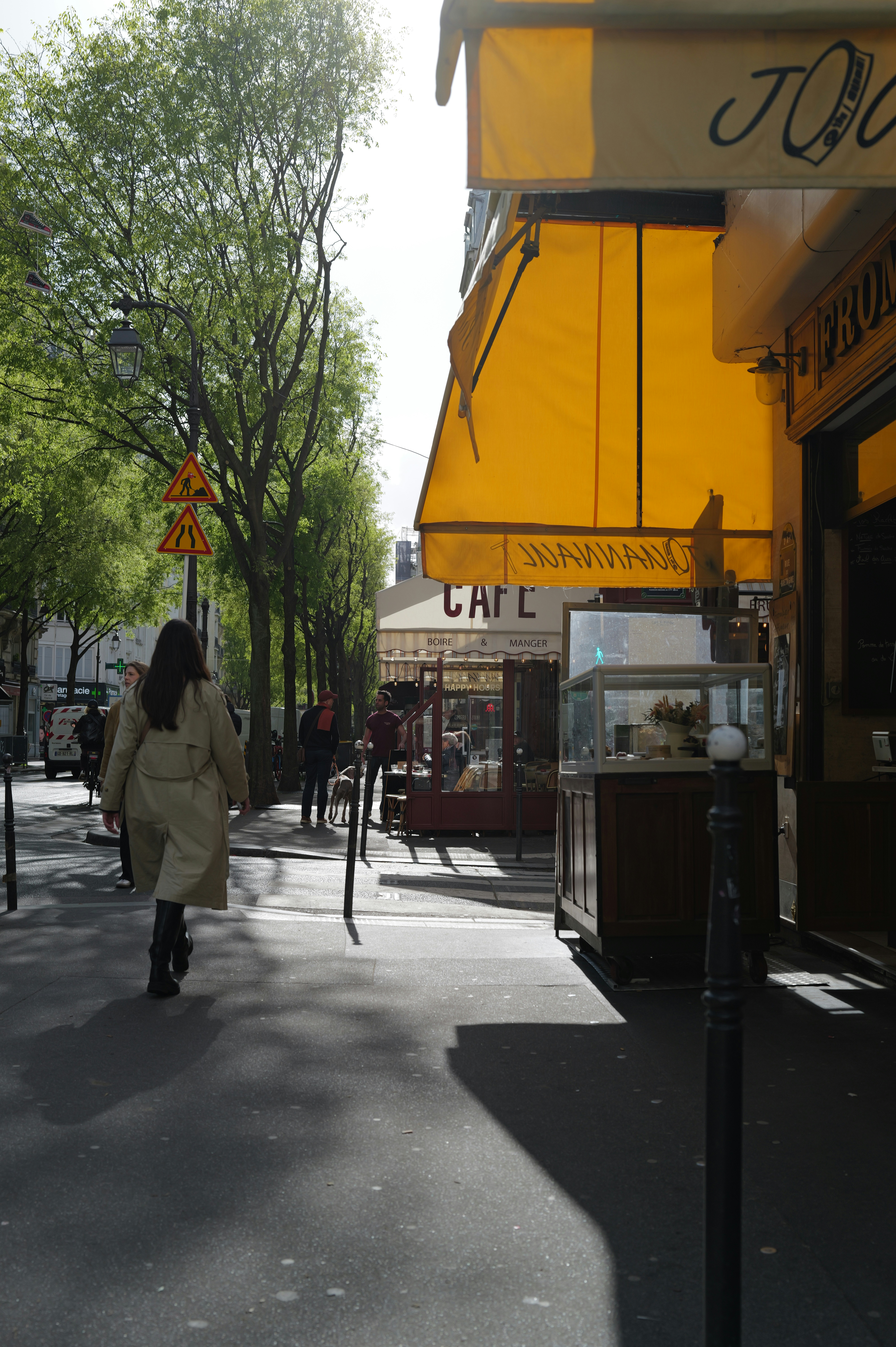 Sunlit Café Corridor: Yellow Awnings and Quiet Pedestrians