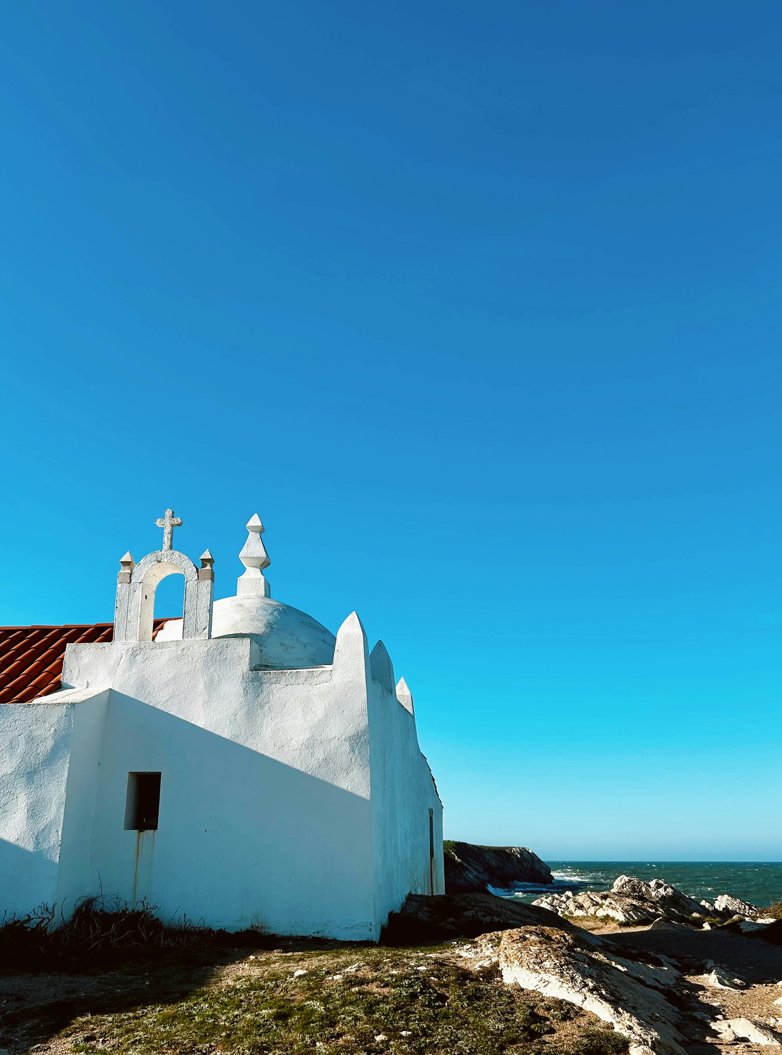 Coastal chapel under a vast blue sky