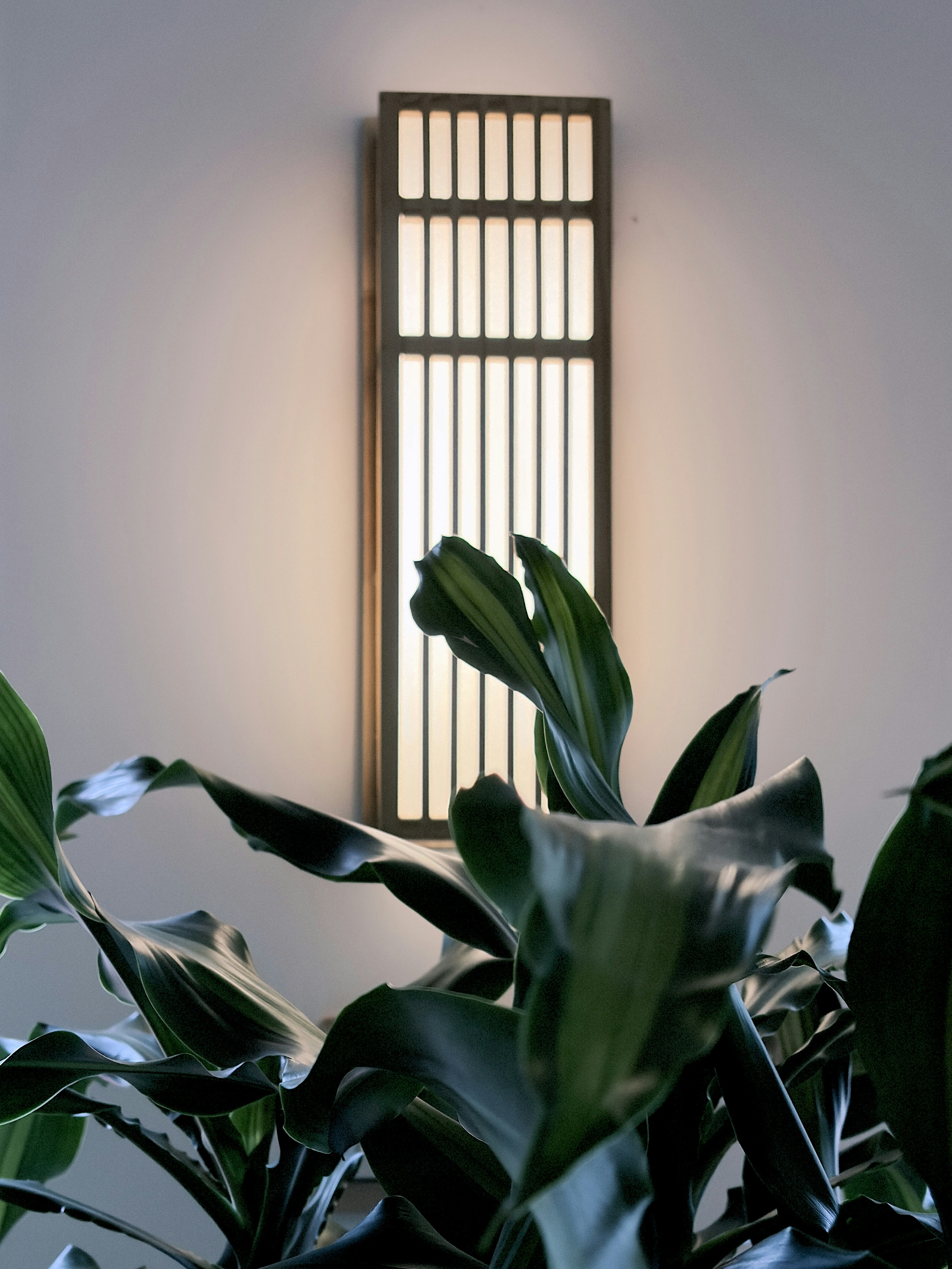 Vertical Lantern Glow Behind Lush Foliage