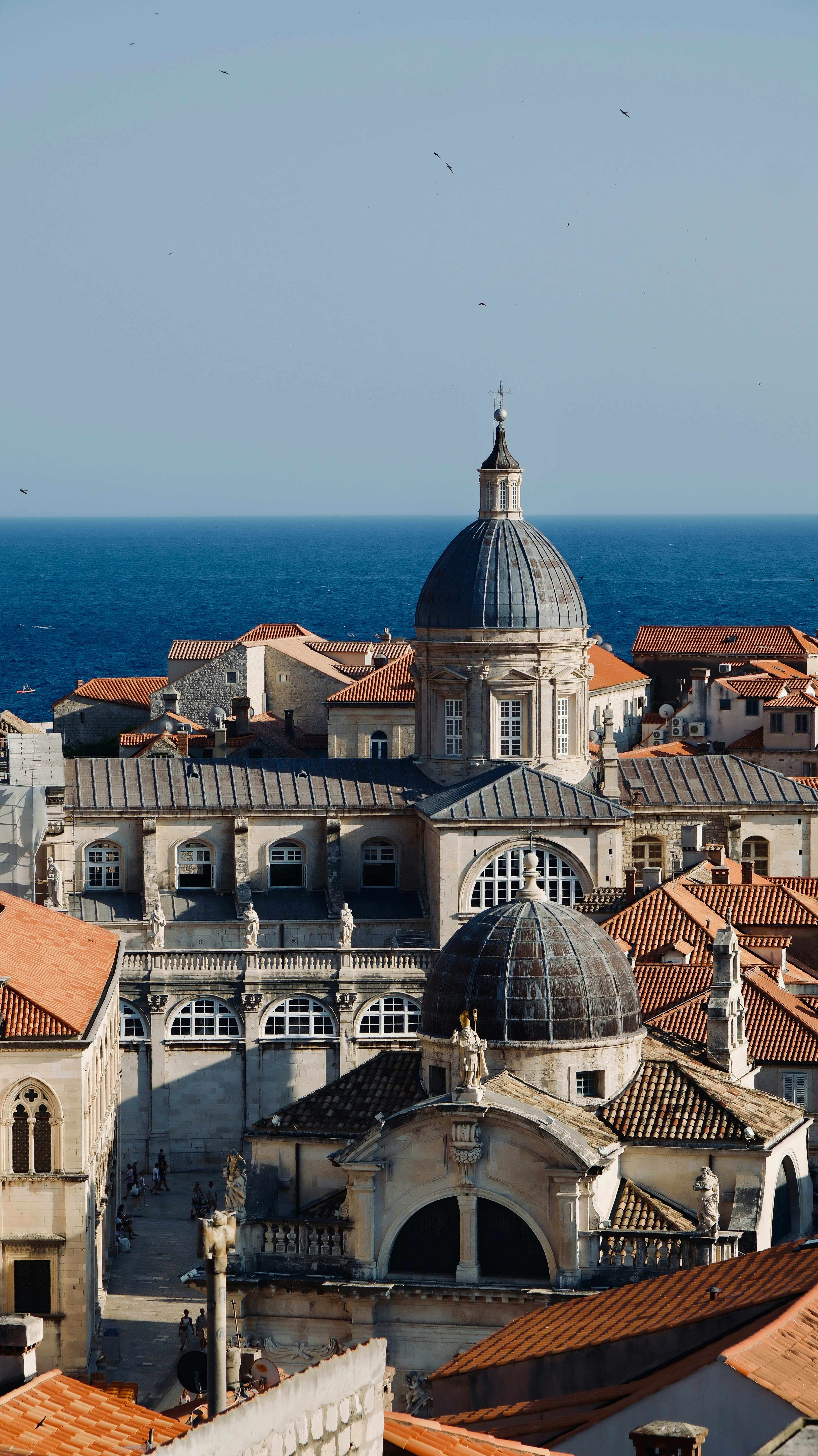 Dome Over Seaside Monastery: Coastal City Rooftops under a Clear Sky