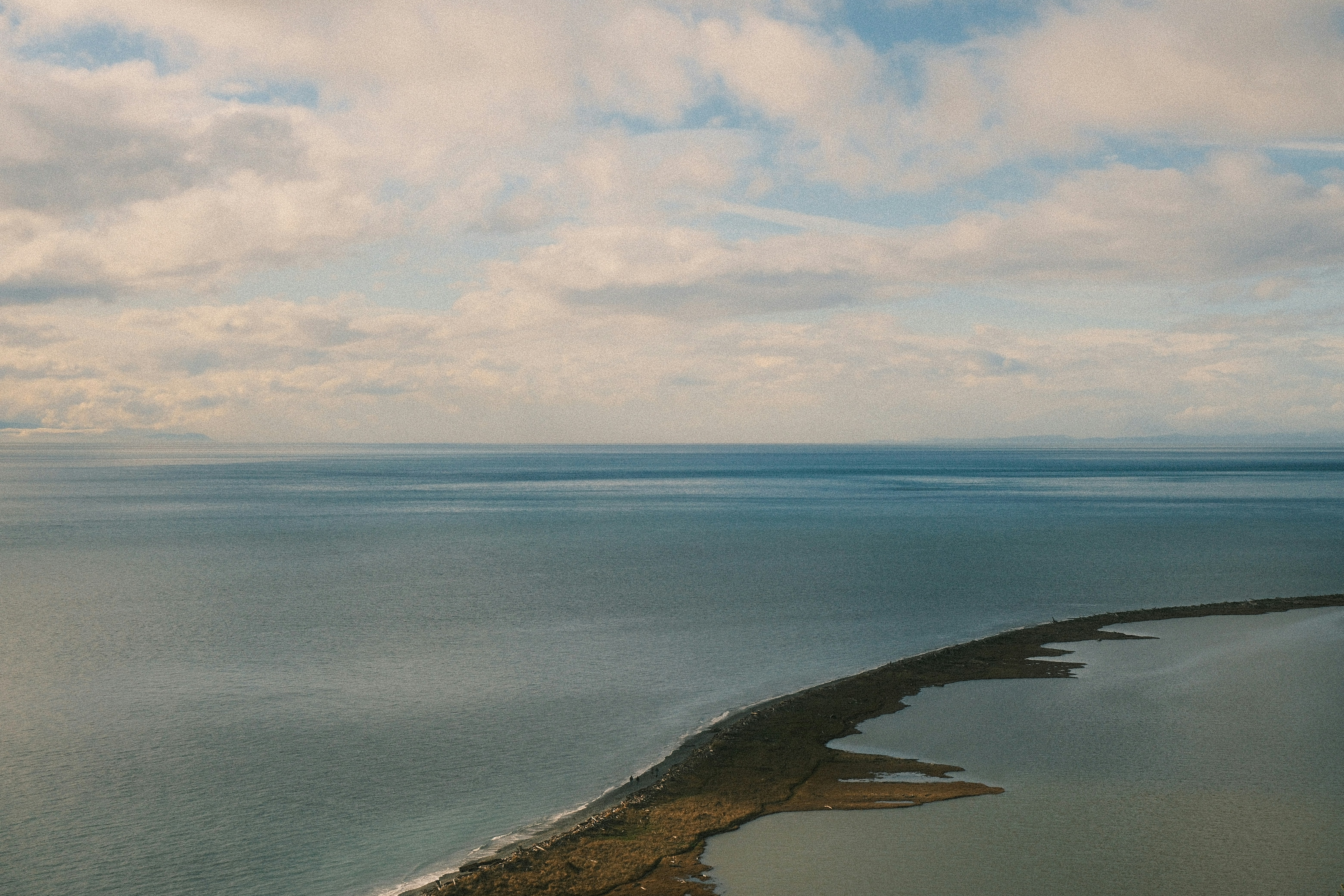 Coastline Quiet: A Distant Shore Stretches Across a Calm Sea