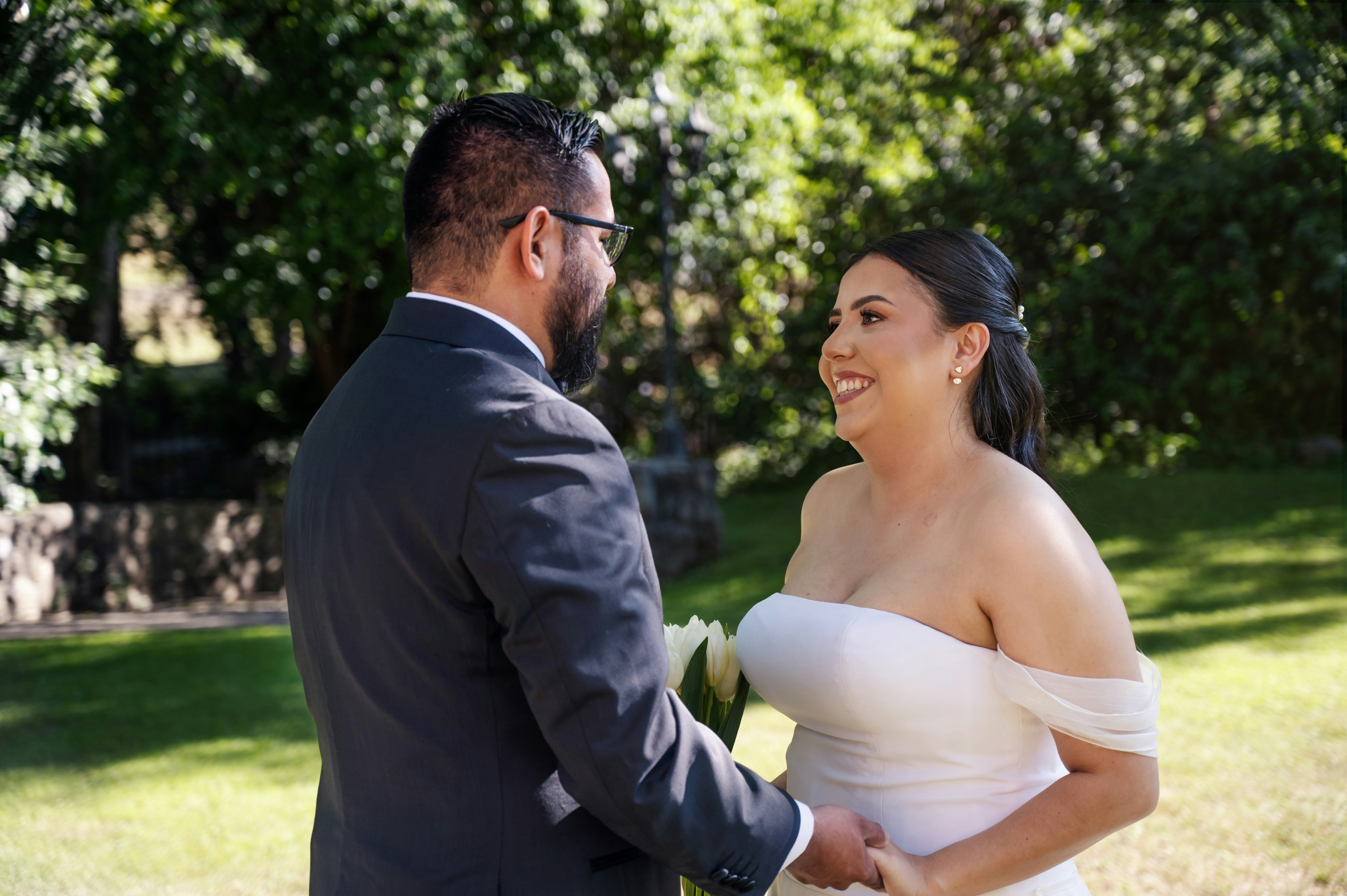 Quiet Exchange: A Bride and Groom Share a Tender Moment in Sunlit Garden