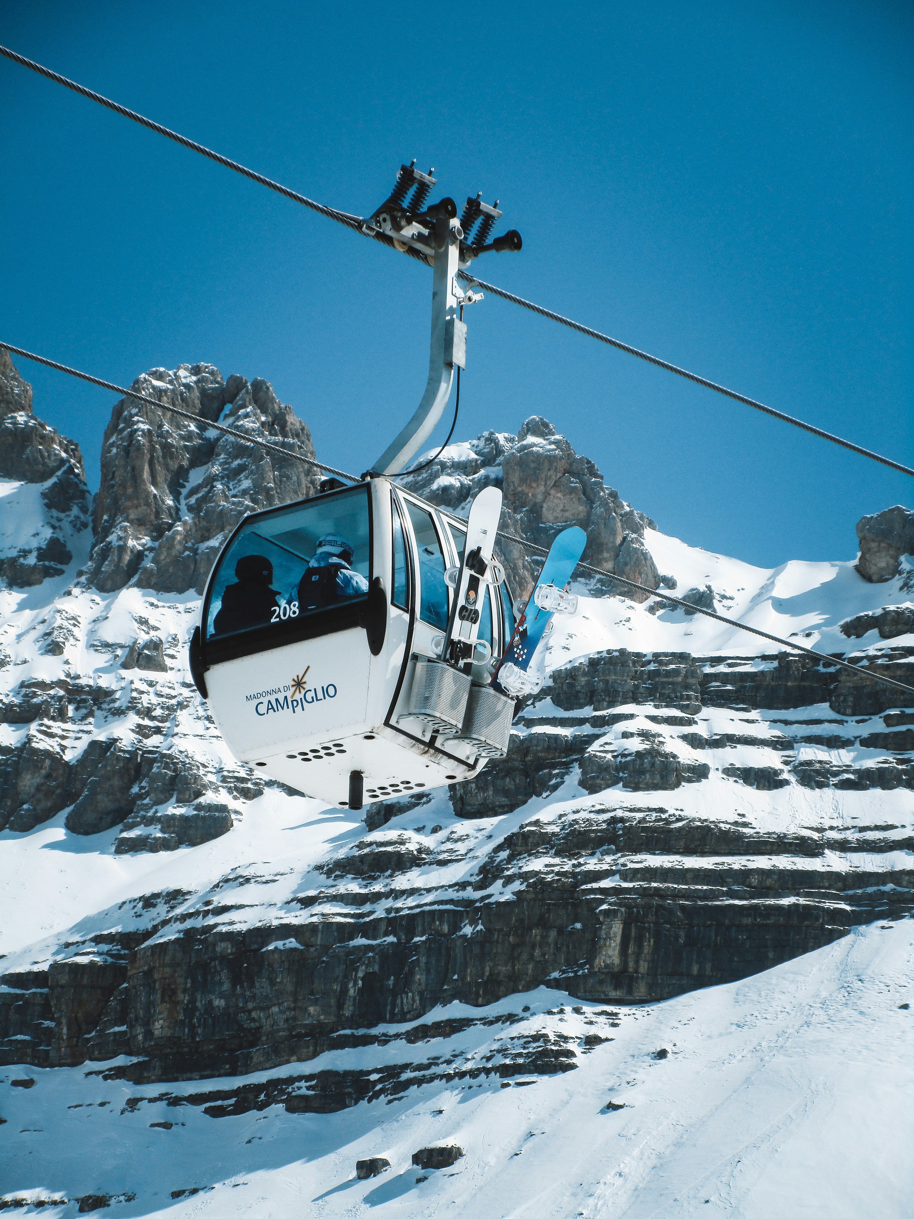 Cable Car Ascent: Snow-etched Peaks and Glass Cab in Motion