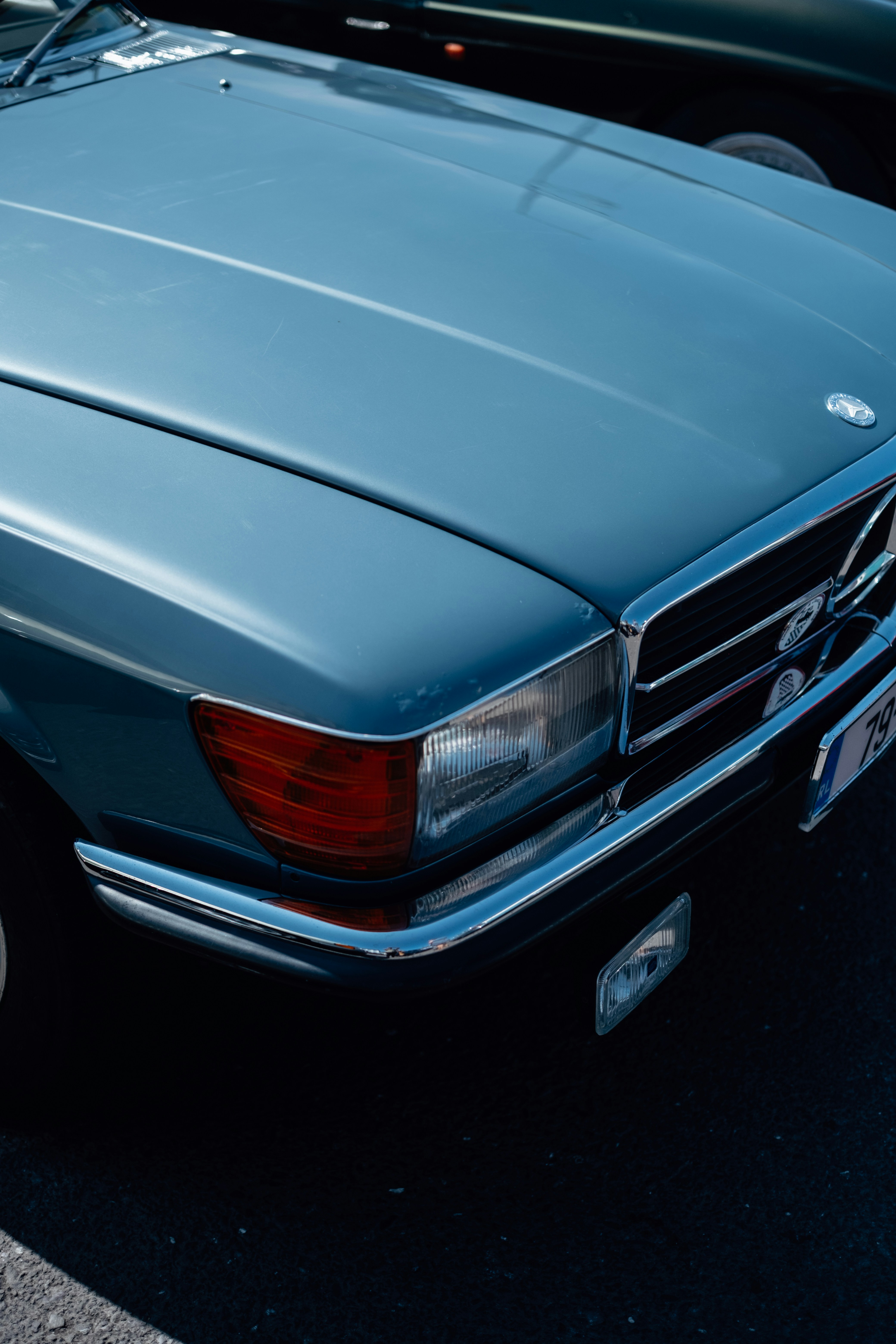 Blue Vintage Mercedes Hood: Chrome Trim and Badge in Noon Light