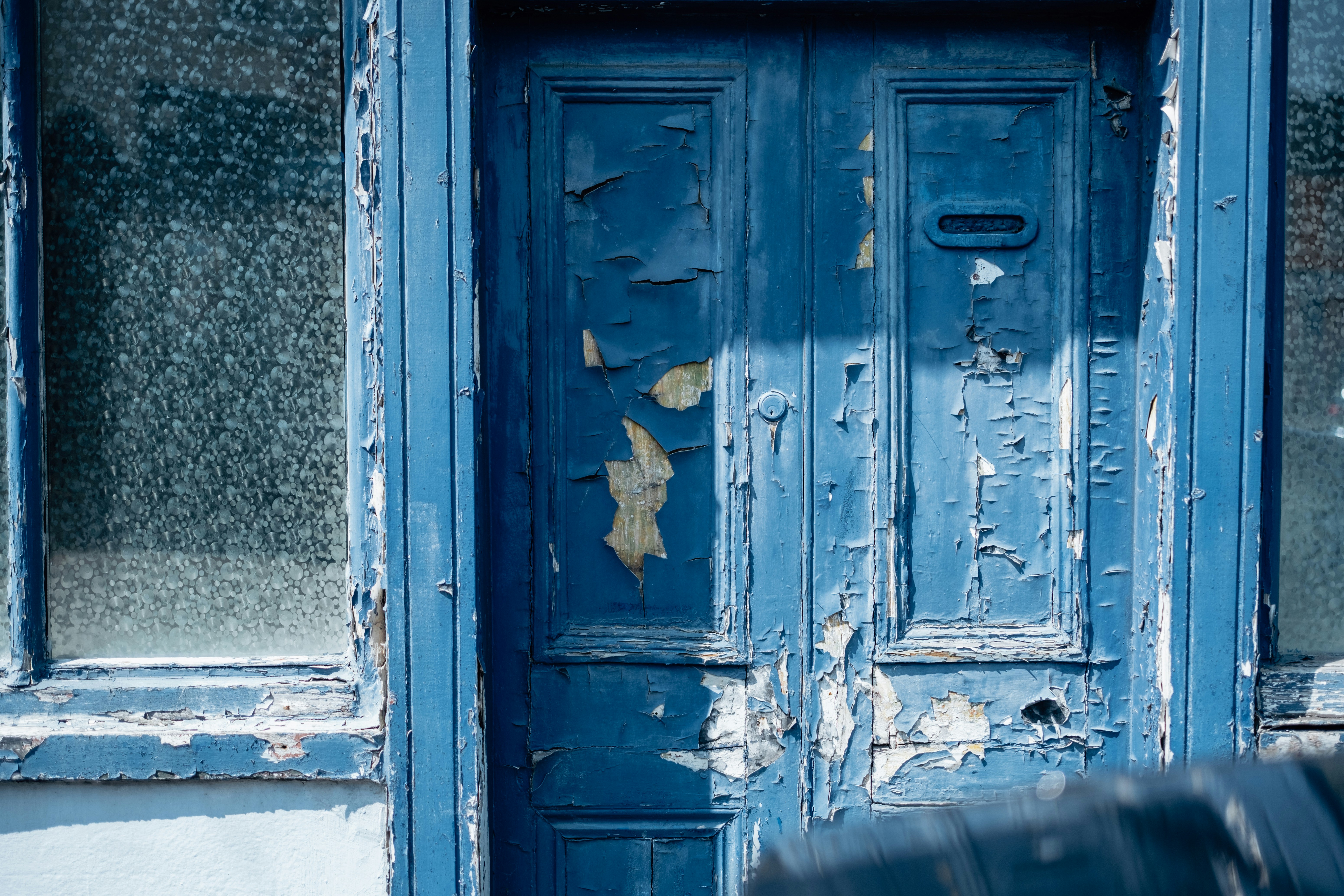 Weathered Blue Door: Peeling paint and a doorway frozen in time