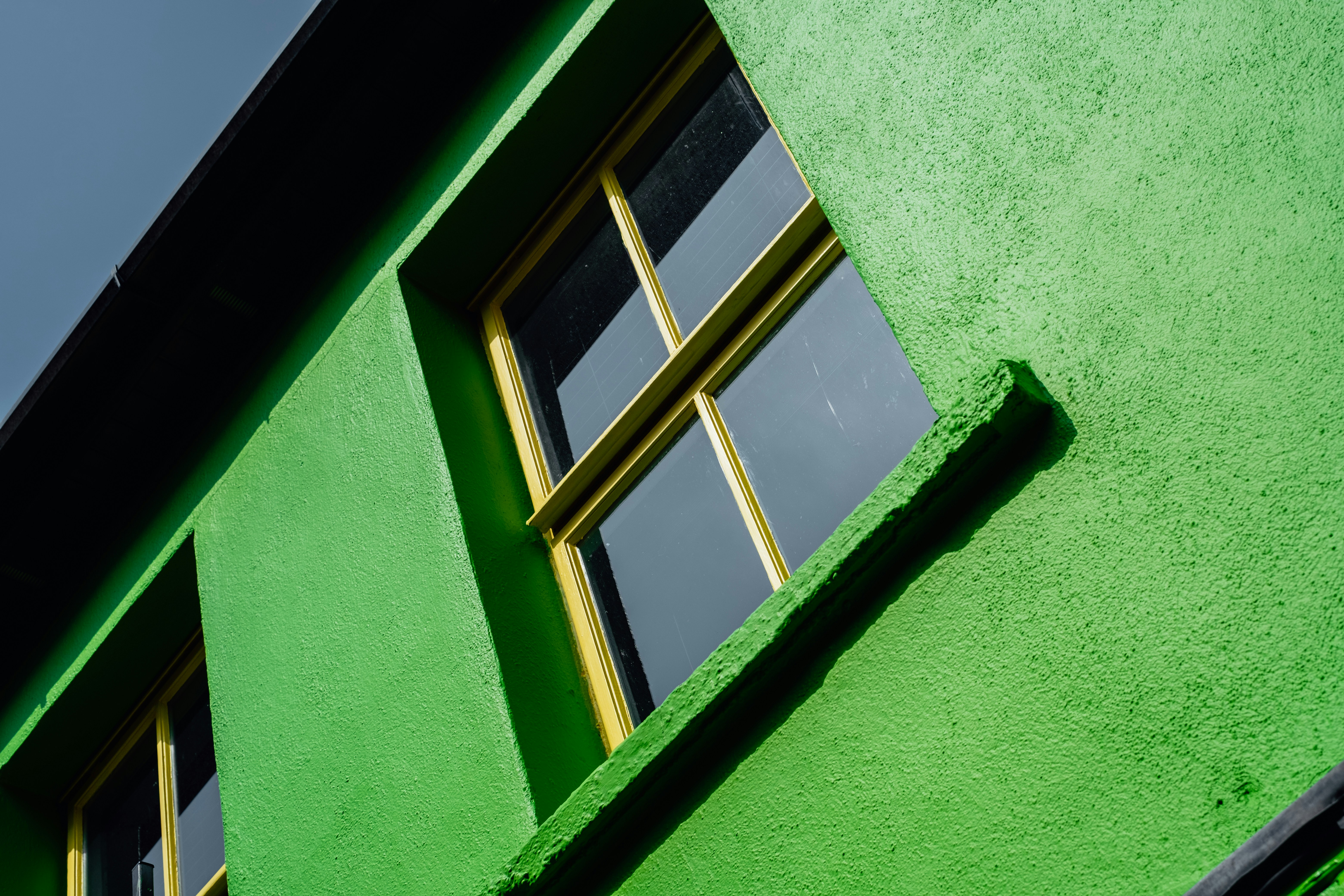 Emerald Facade: A Sunlit Window on a Lime Wall