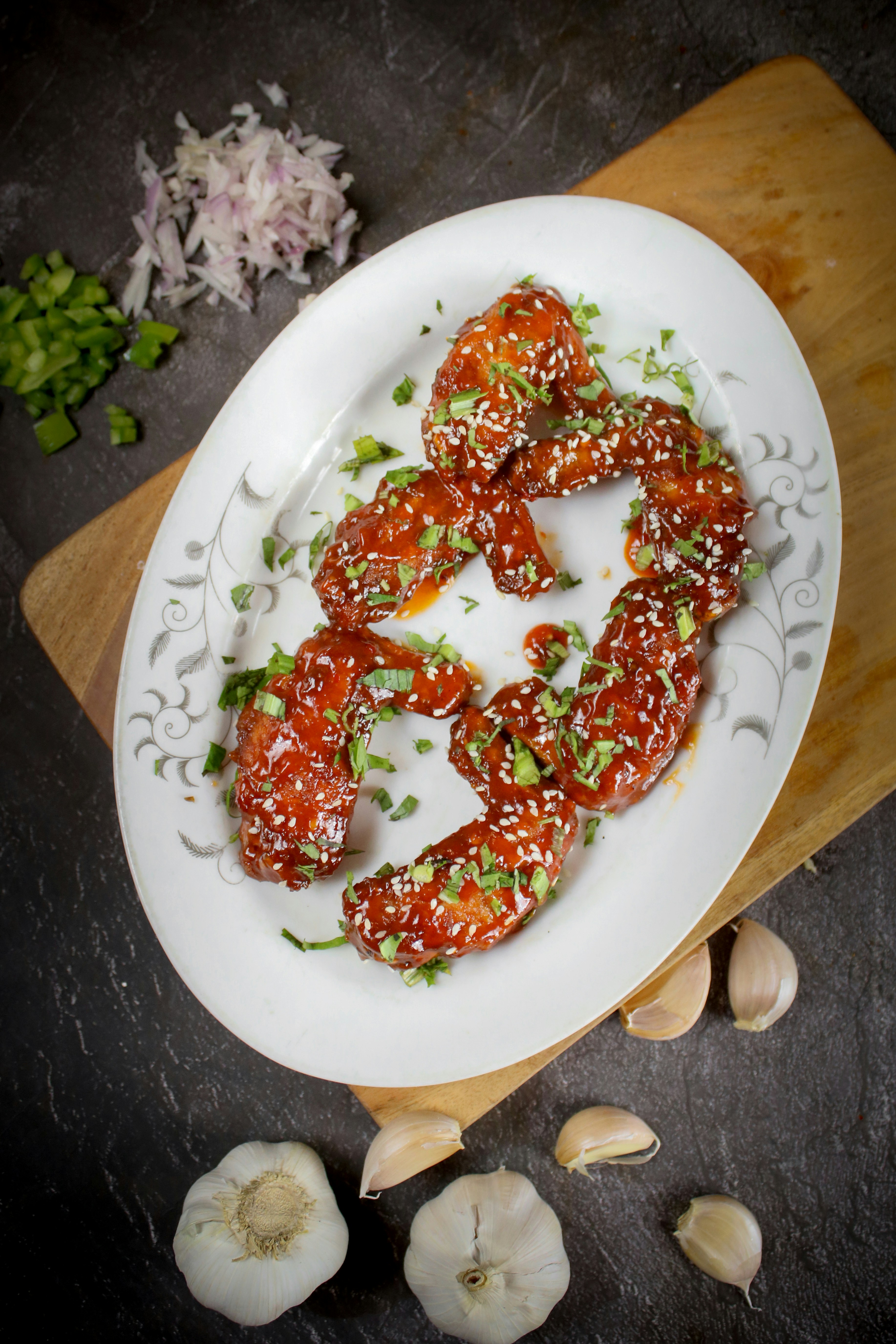Sticky glazed shrimp bites arranged on a white patterned platter