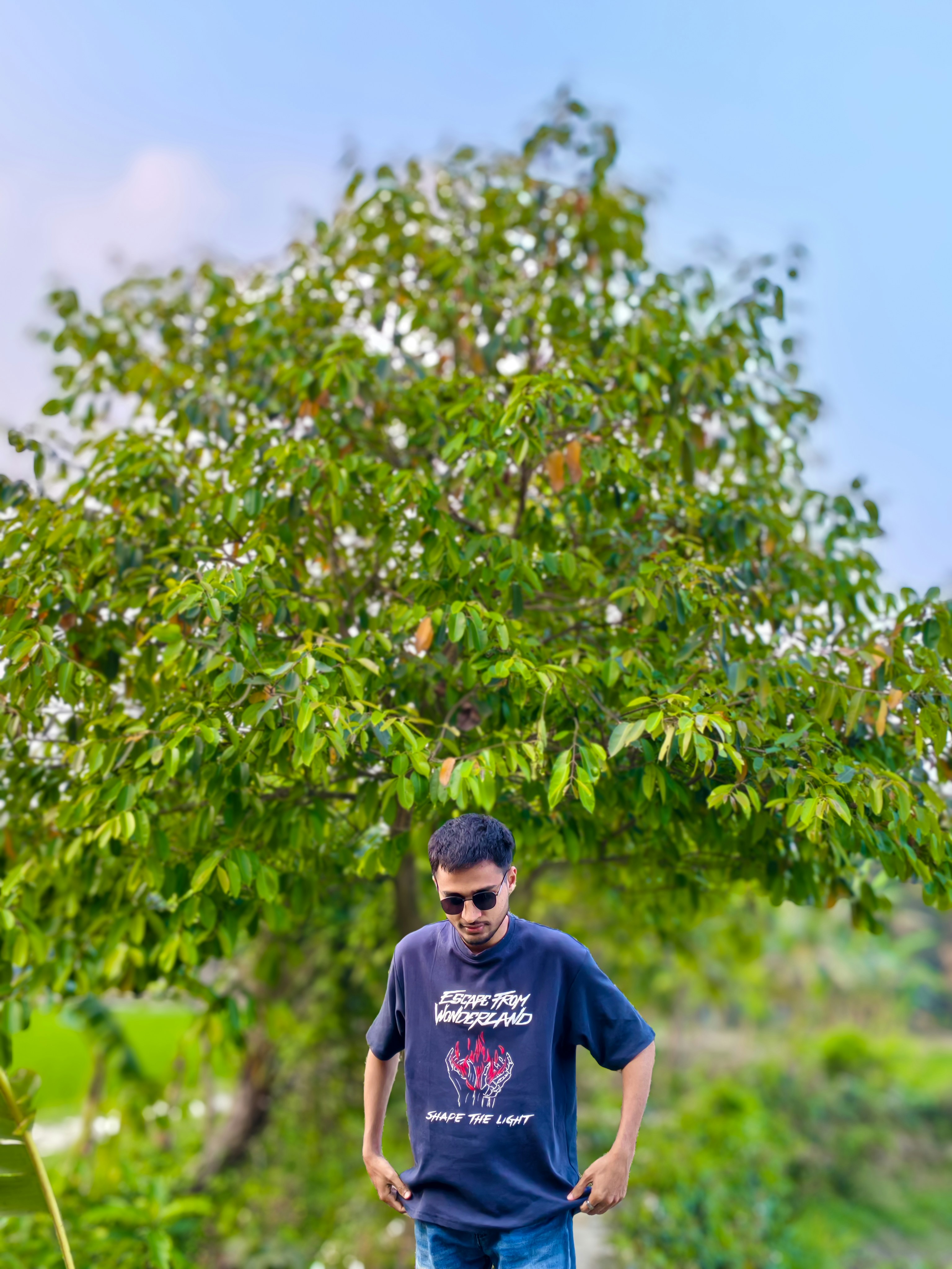 Rooted in Focus: A Relaxed Portrait Beneath Verdant Canopy