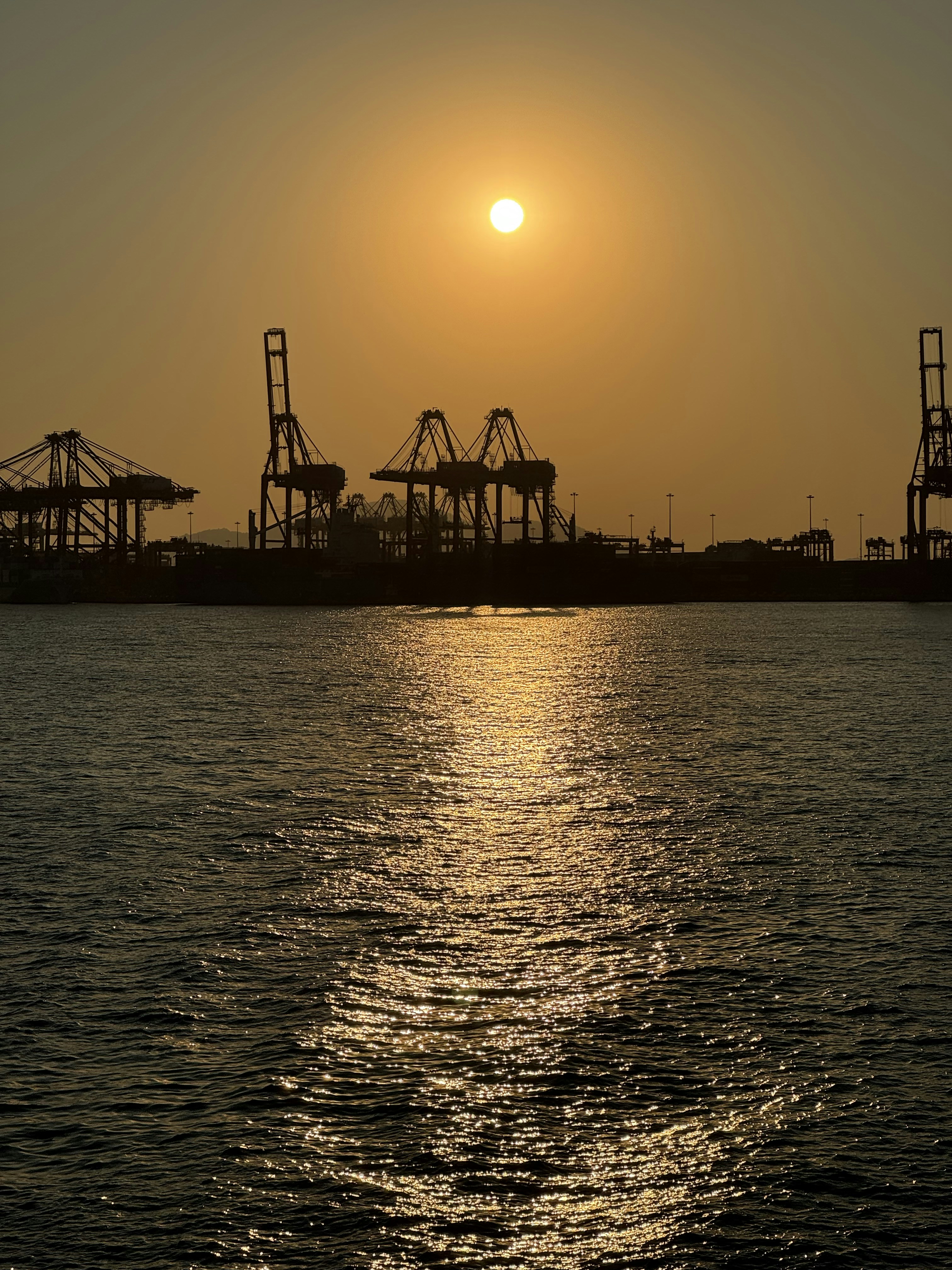 Sunlit port rails at dusk over rippled water