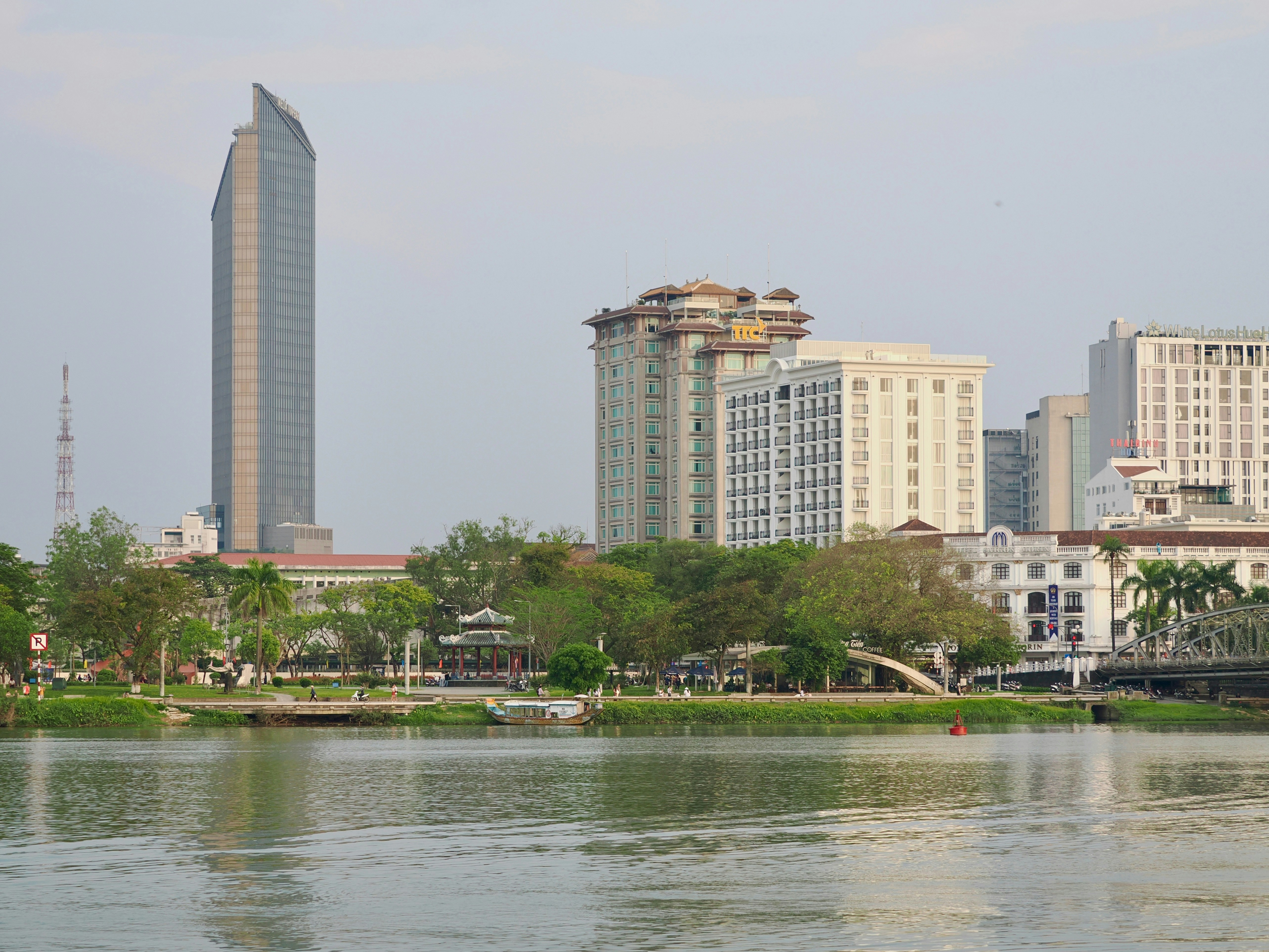 Sunlit Riverside Skyline with Towering Modern Buildings
