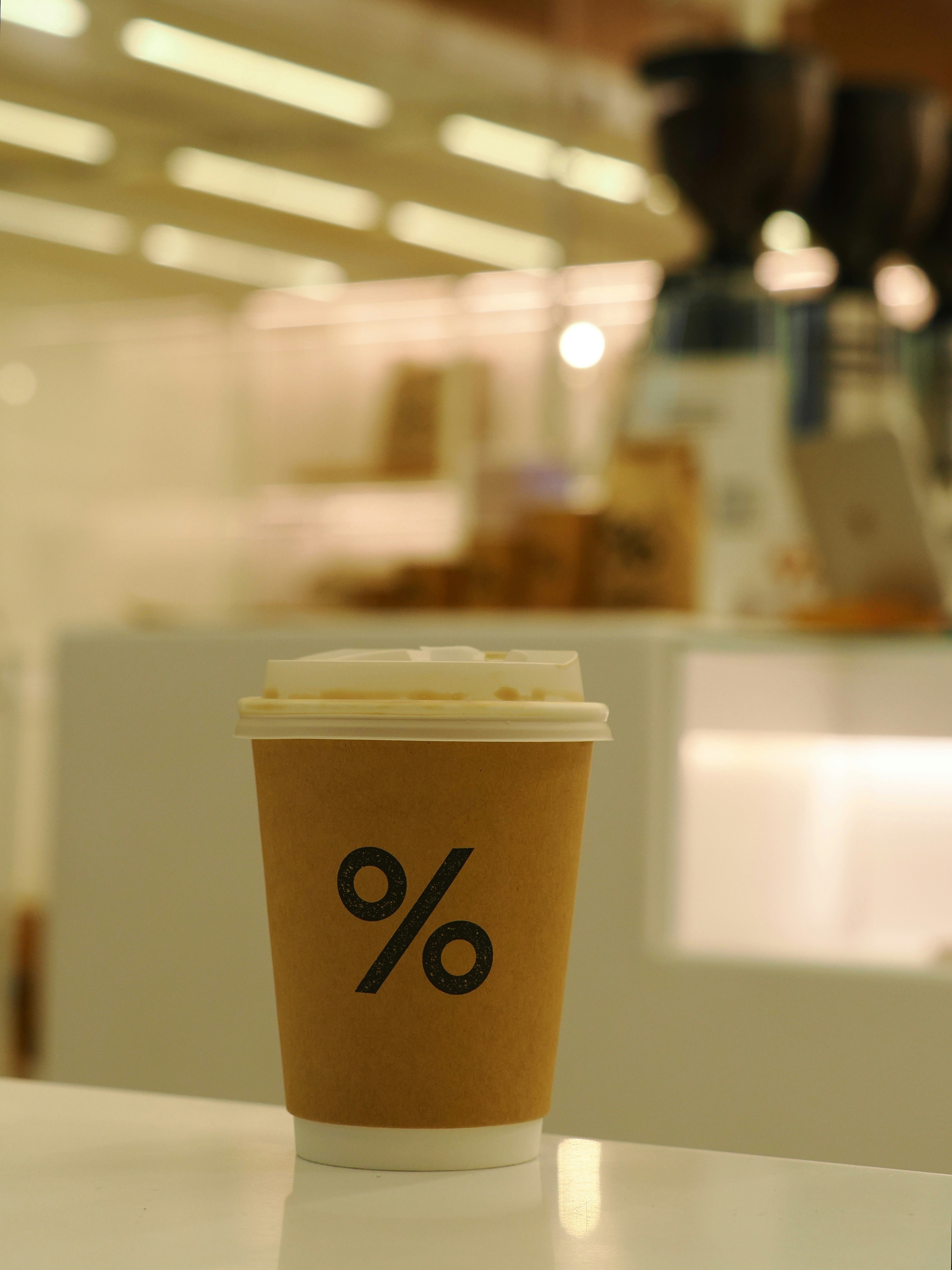Central Cup with Percentage Symbol in Softly Lit Café