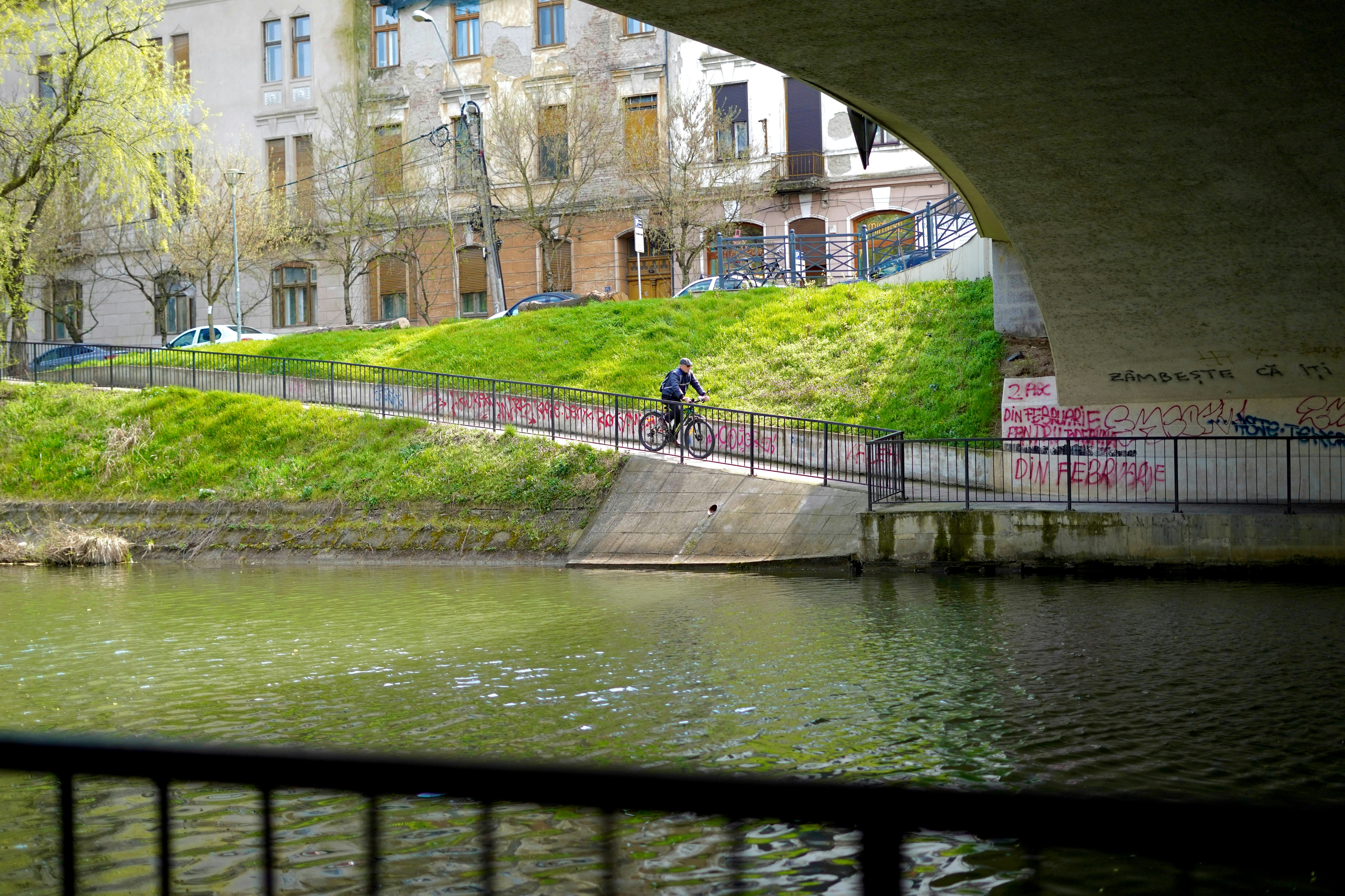 Biker on a Canal Path beneath the City Arch