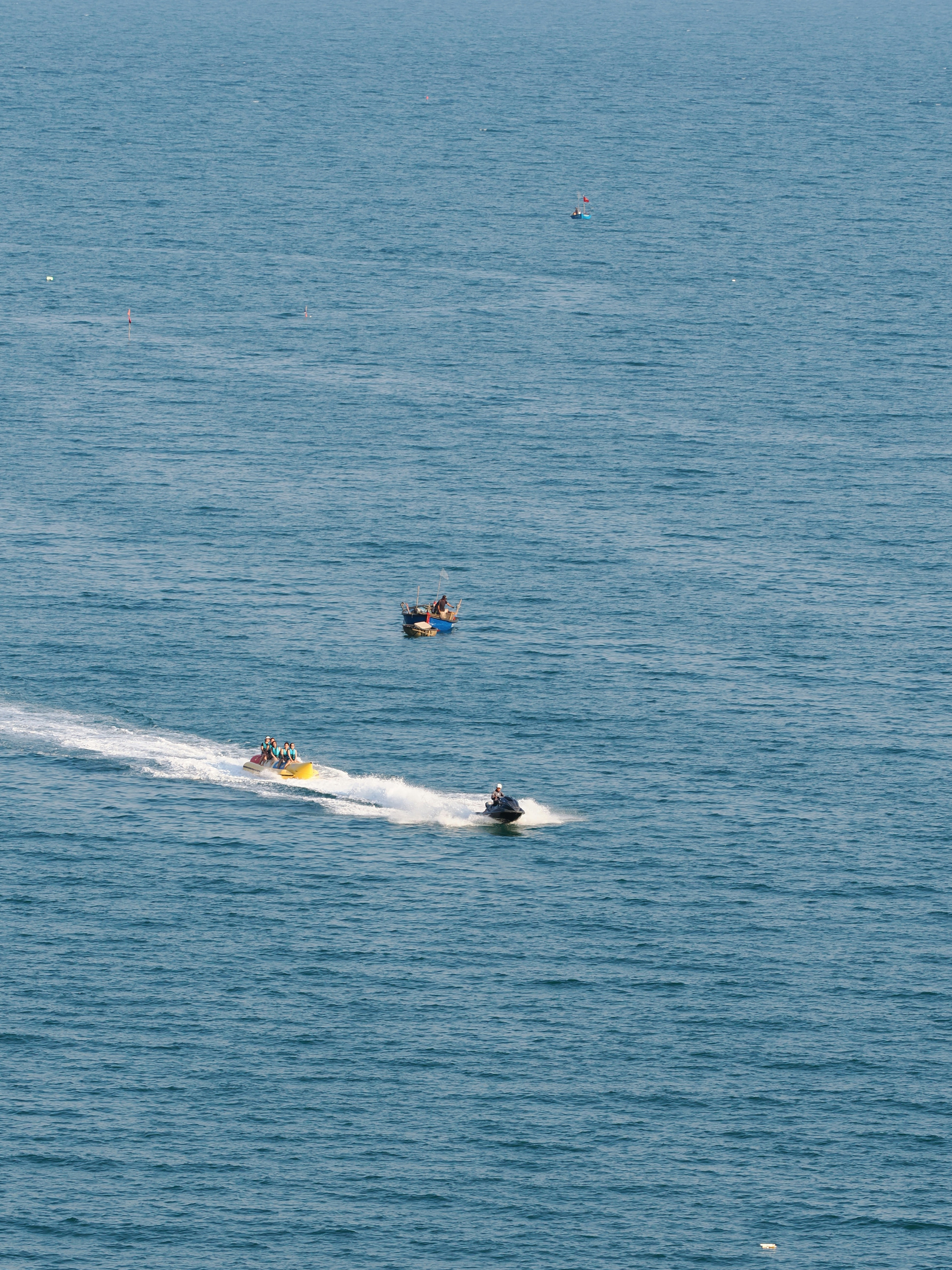 Jet Skis on Wide Ocean: White Wake and a Distant Boat