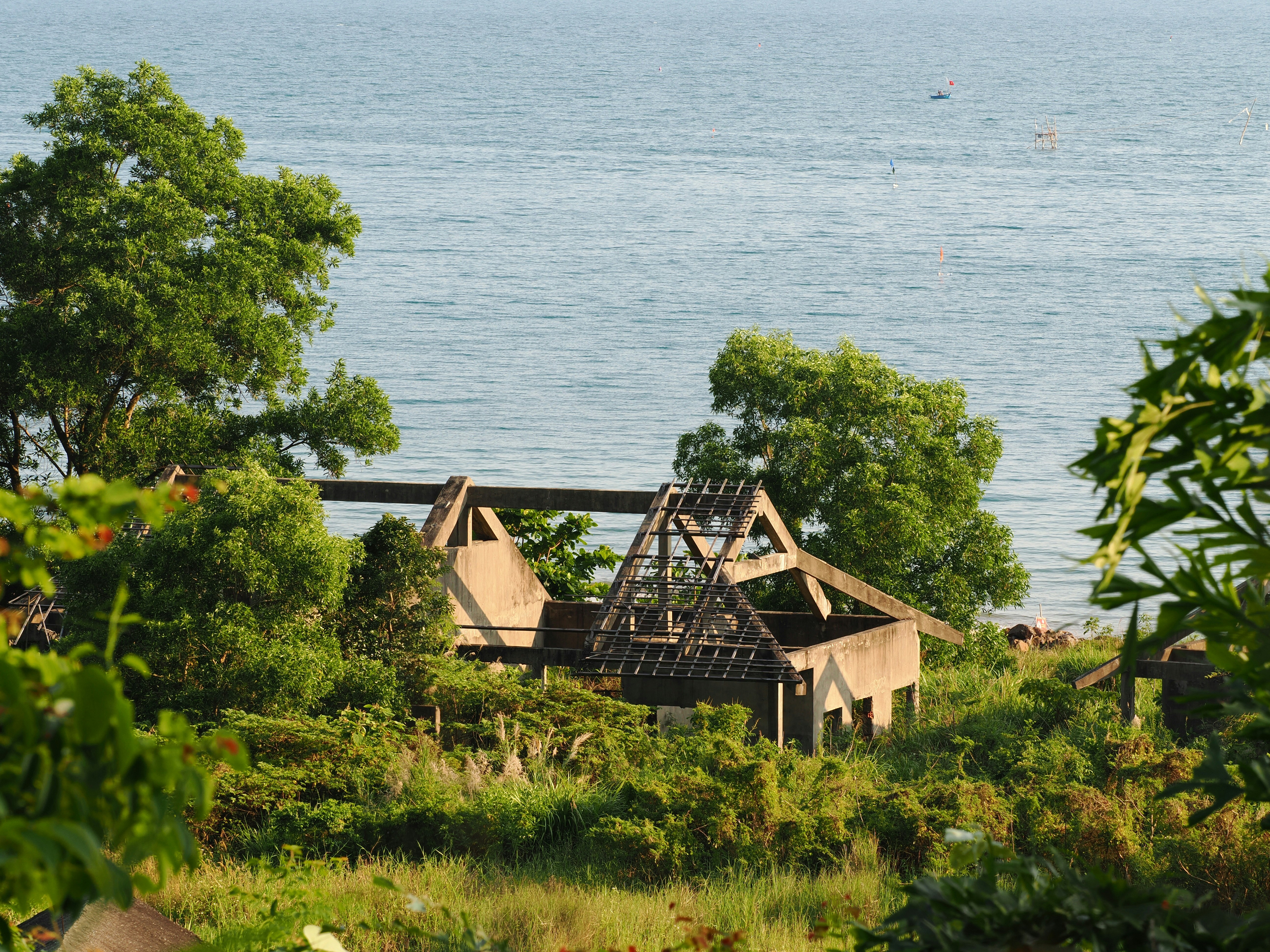Terraced ruin by the sea: a weathered structure embraced by greenery