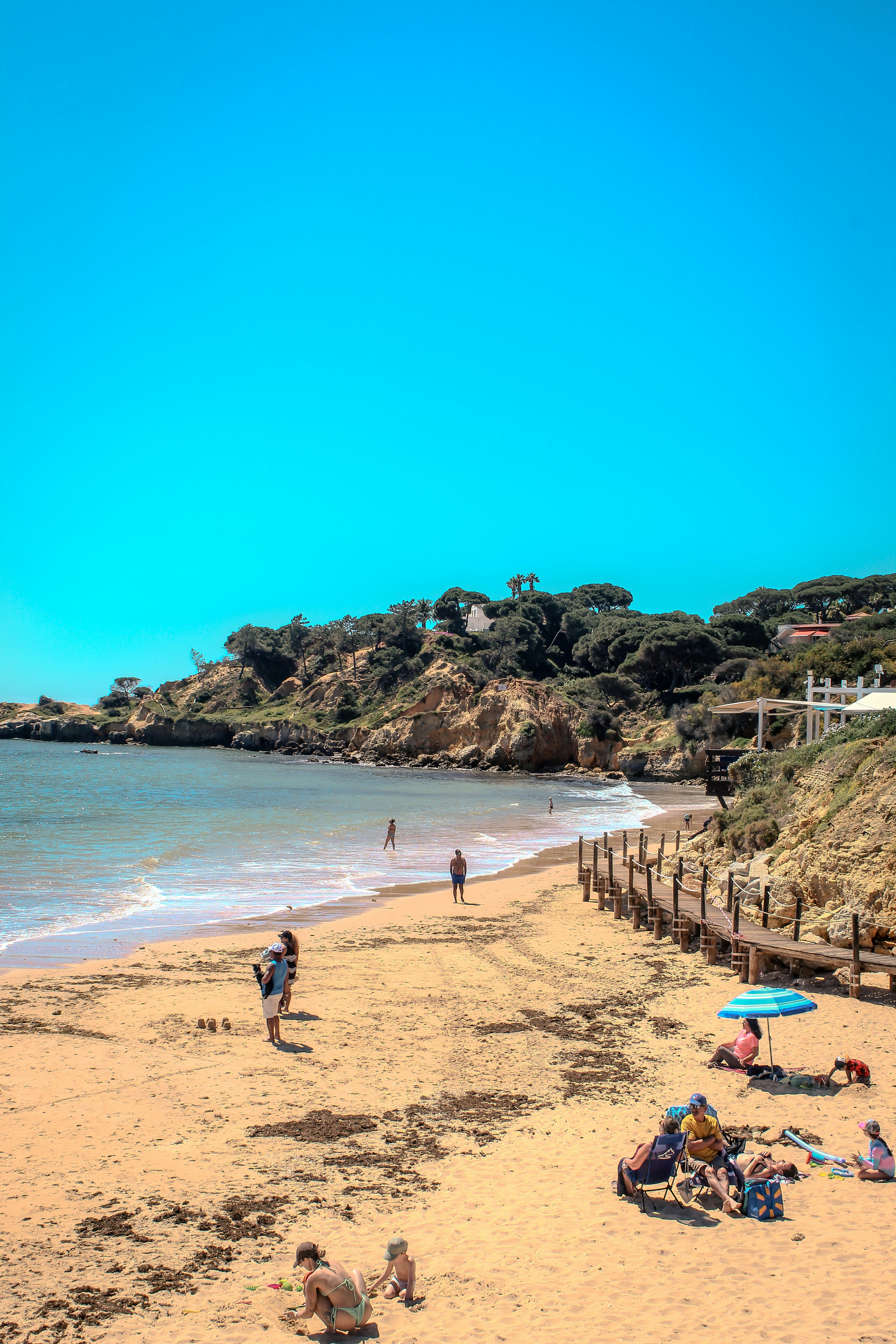 Sunlit Coastline: A Quiet Beach Day Beside rocky promontories