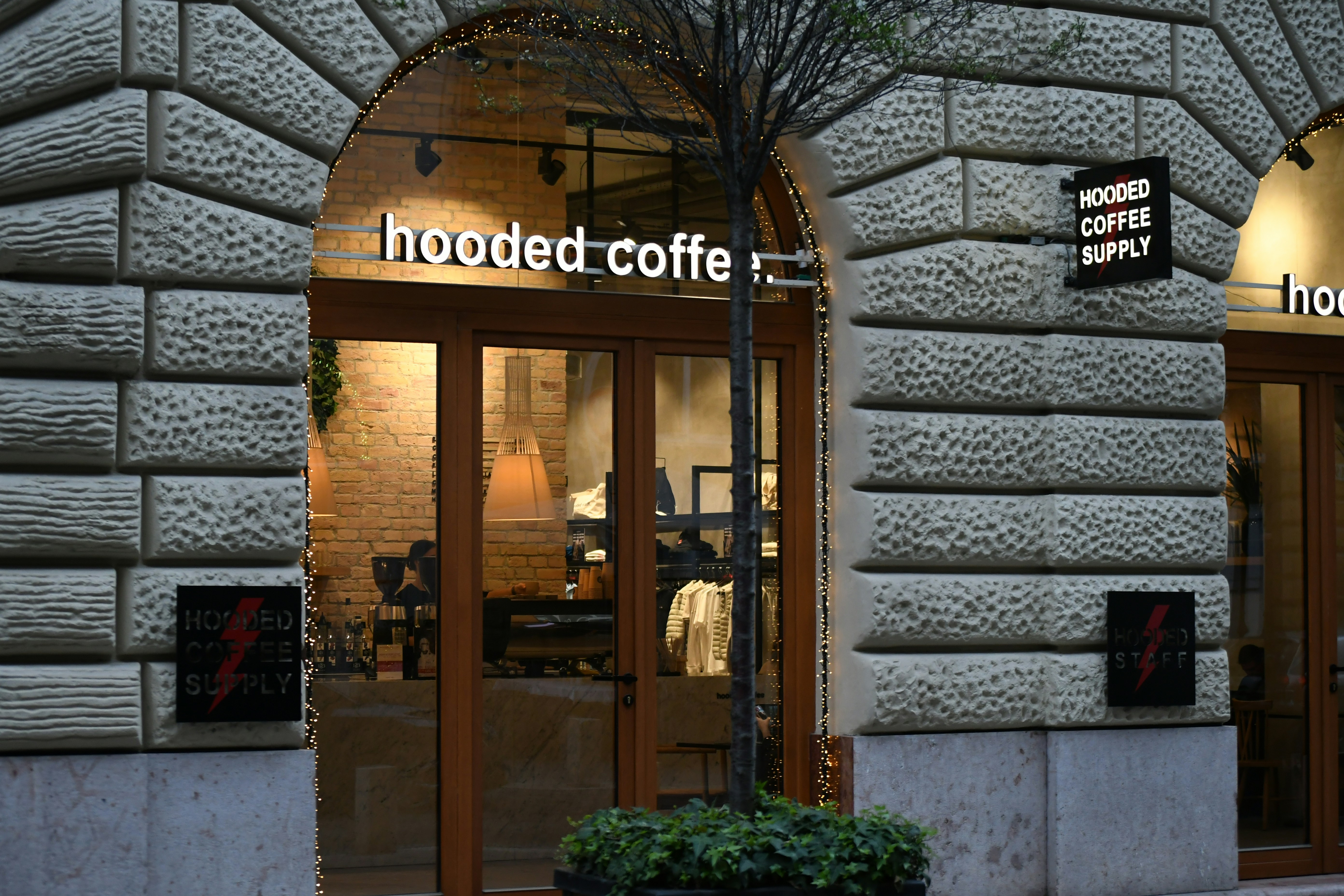 Hooded Coffee: Street-facing Archway Framing a Café Door