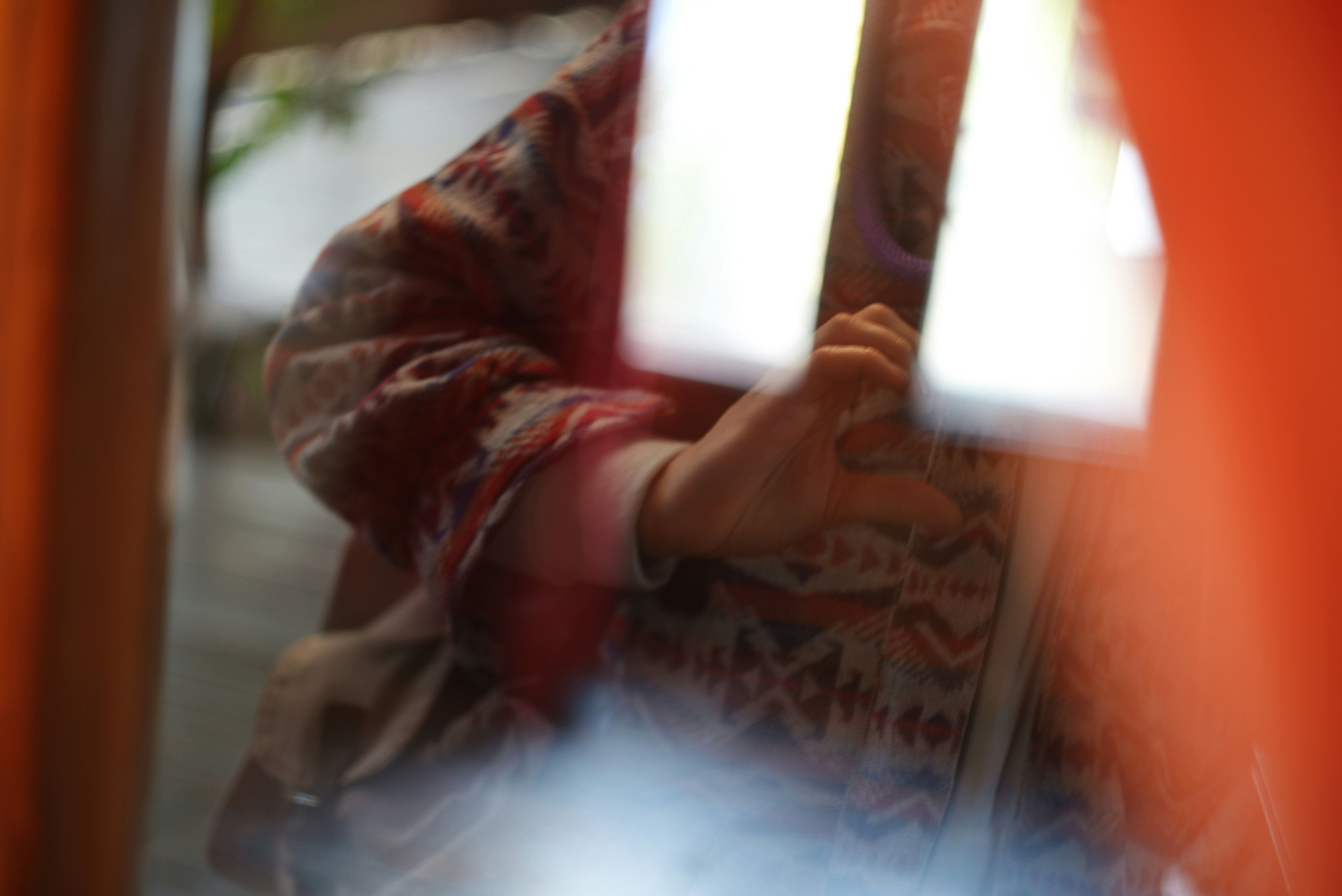 Framed in Reflection: A Quiet Hand Amid Soft Textile Patterns