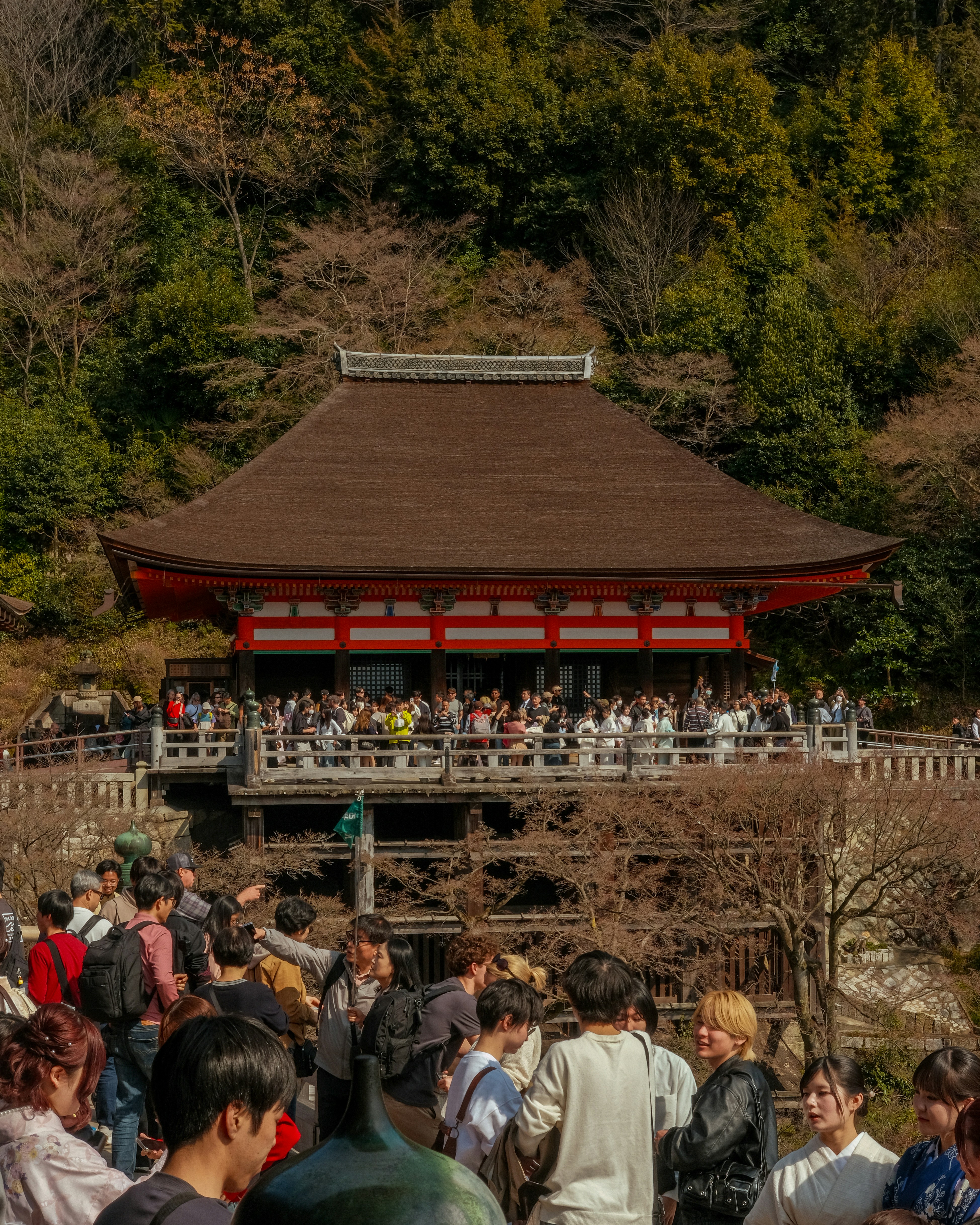 Temple on a crowded bridge: autumn flow beneath the red-roofed sanctuary