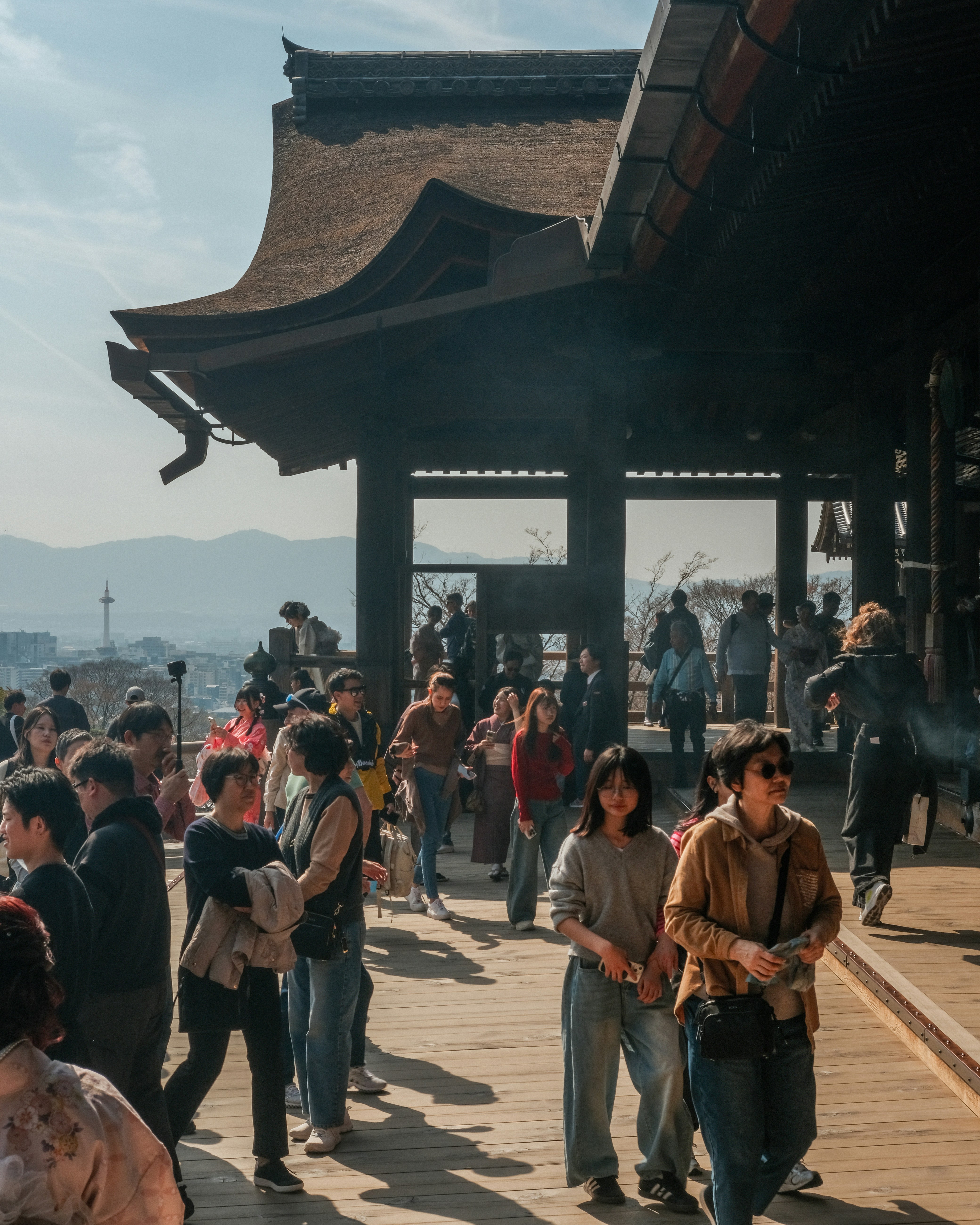 Crowded Temple Terrace: People Seek Shade Beneath a Traditional Roof