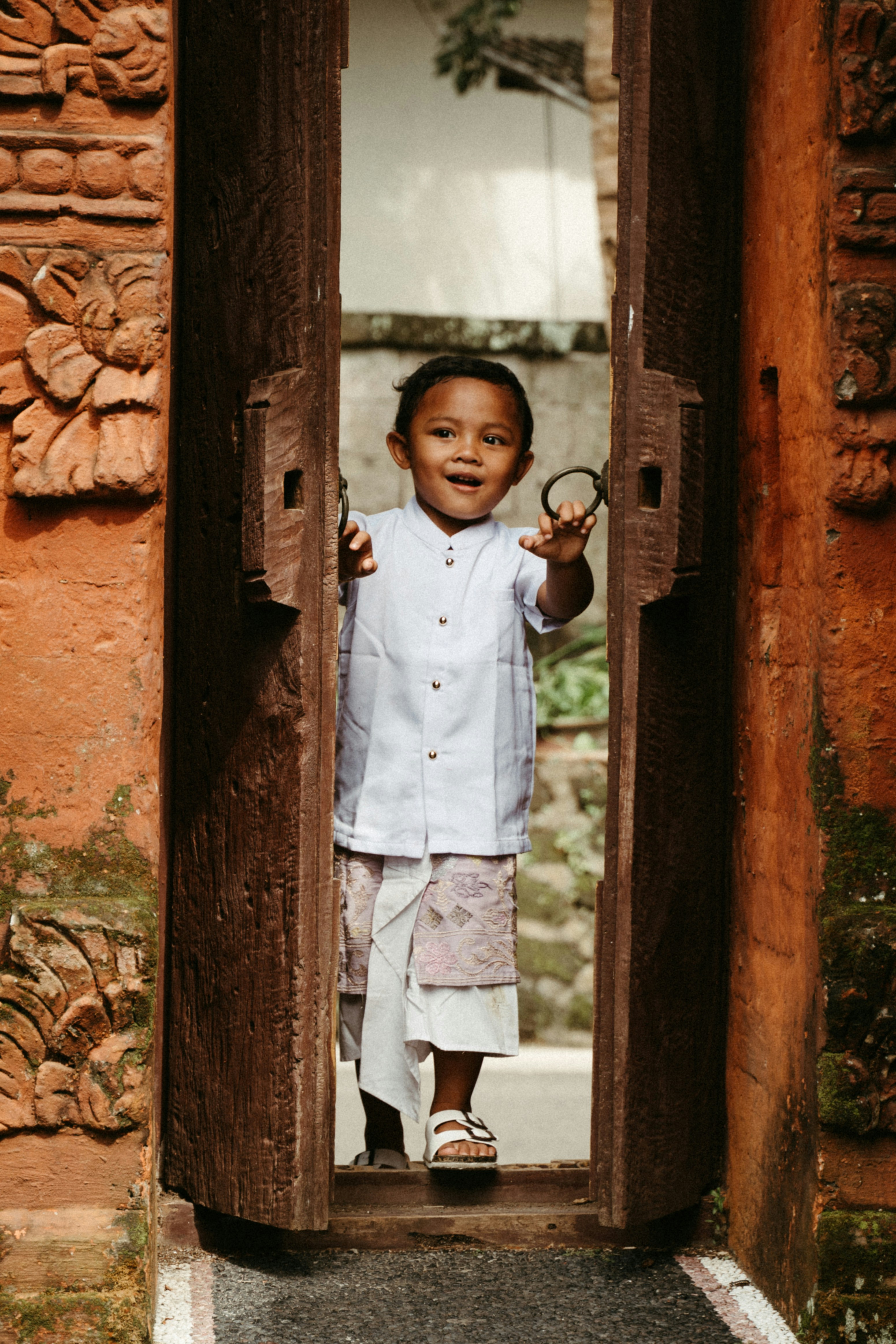 Child in a Doorway: A Bright Moment Beyond the Rustic Frame
