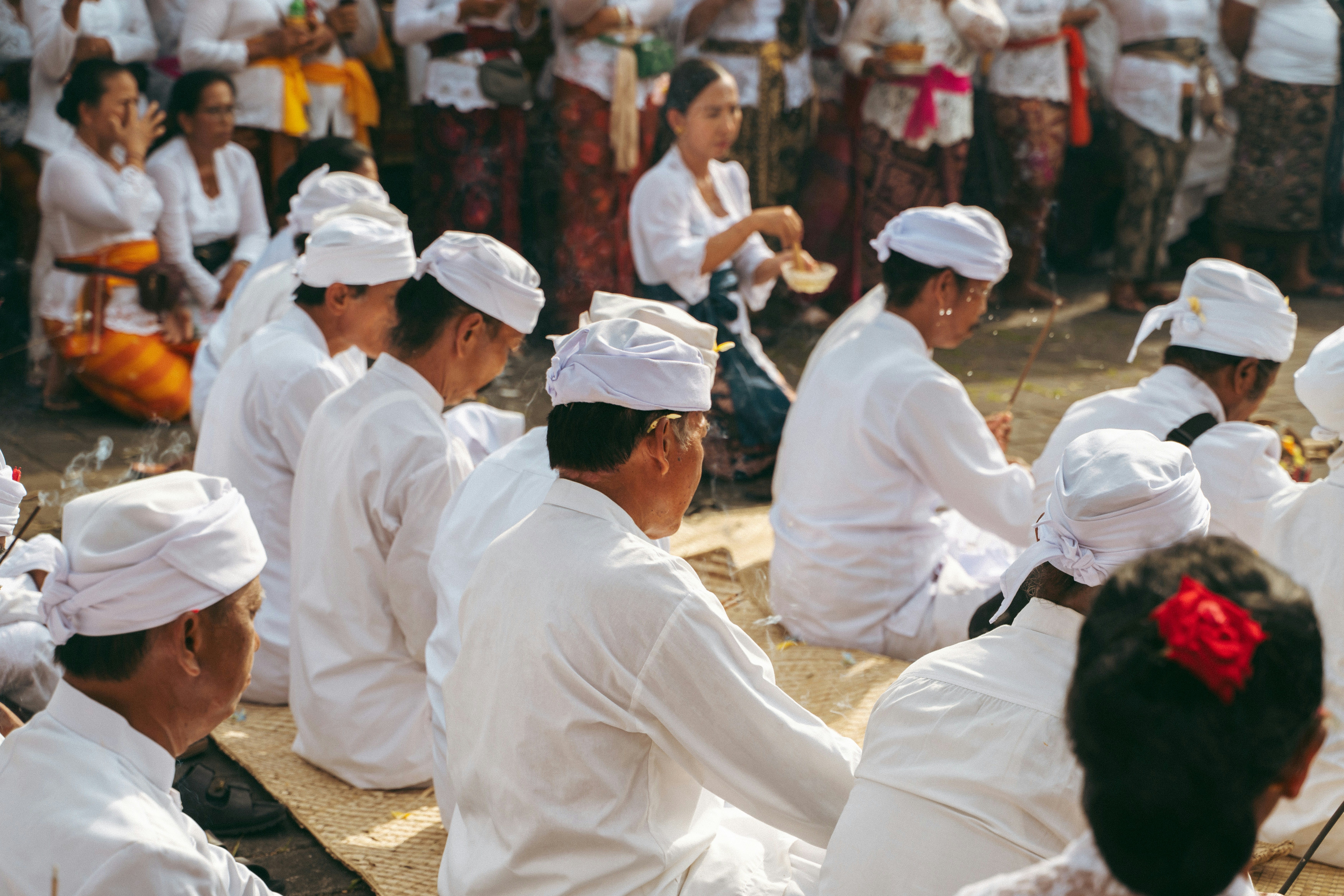 Group of Traditional Performers in White Attire Gathered Around a Sacred Platform