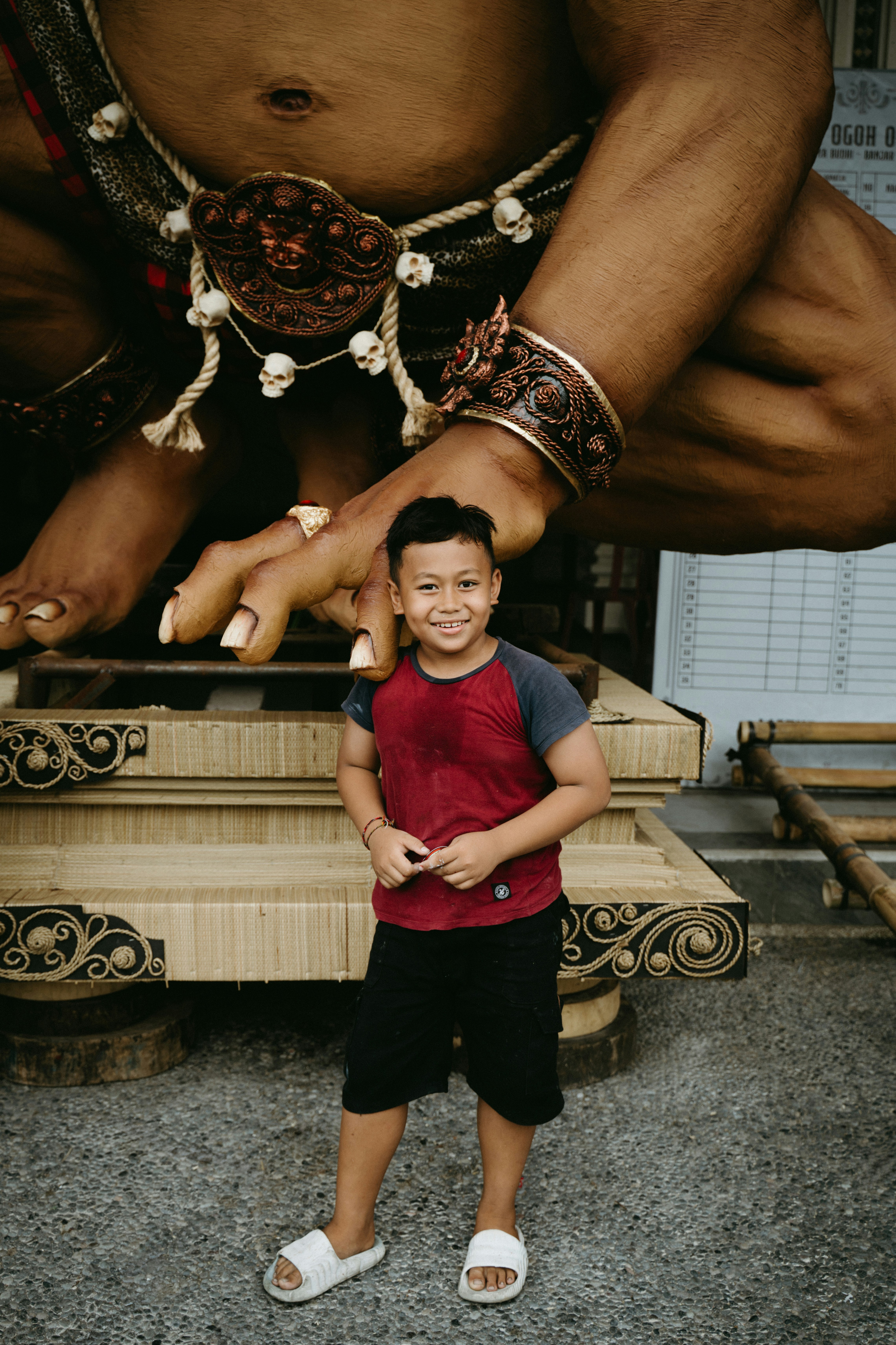 Child in front of a colossal statue's hand: a moment of scale and wonder