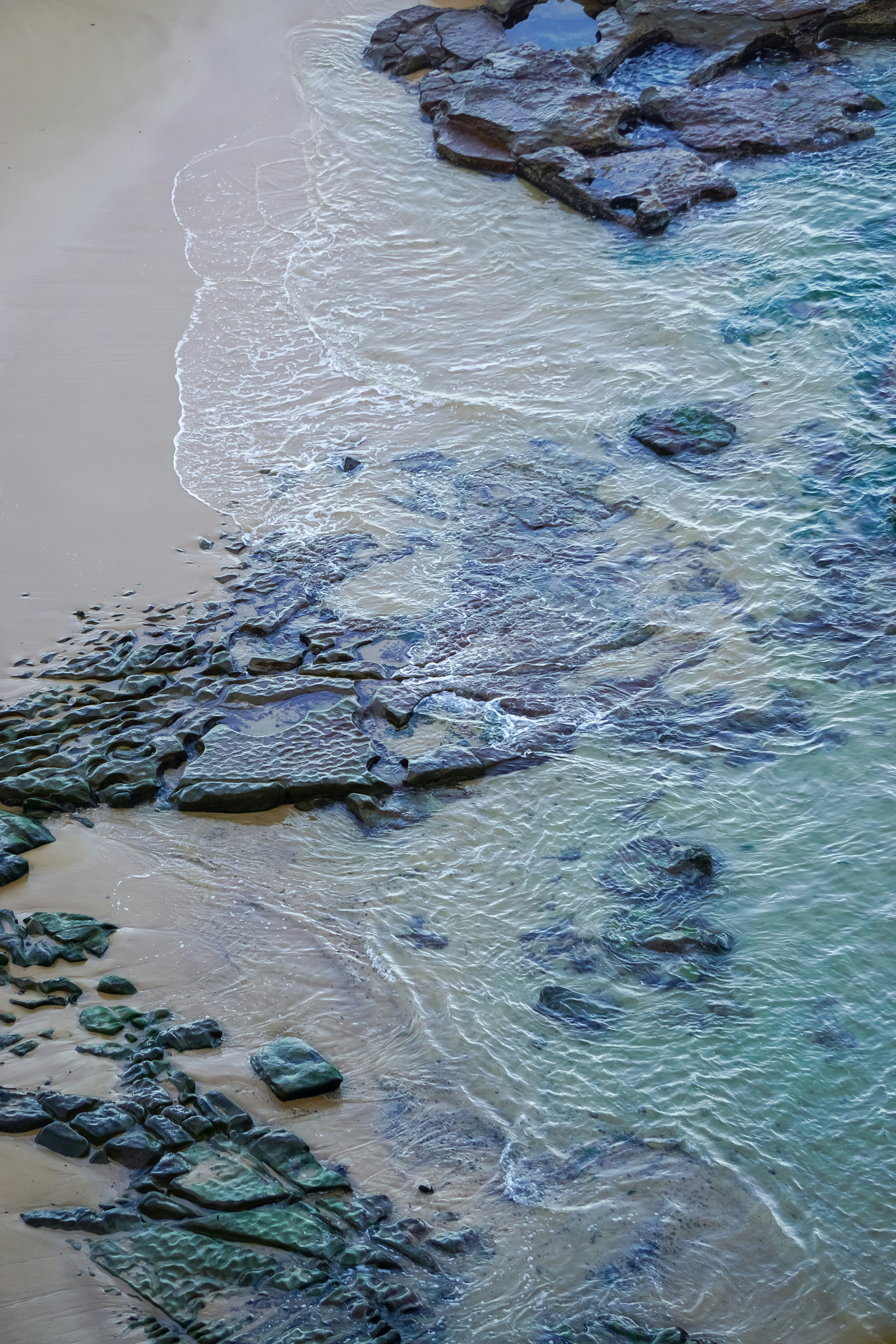 Sapphire Tide: Rocks and Turquoise Shoreline in Quiet Reef Light
