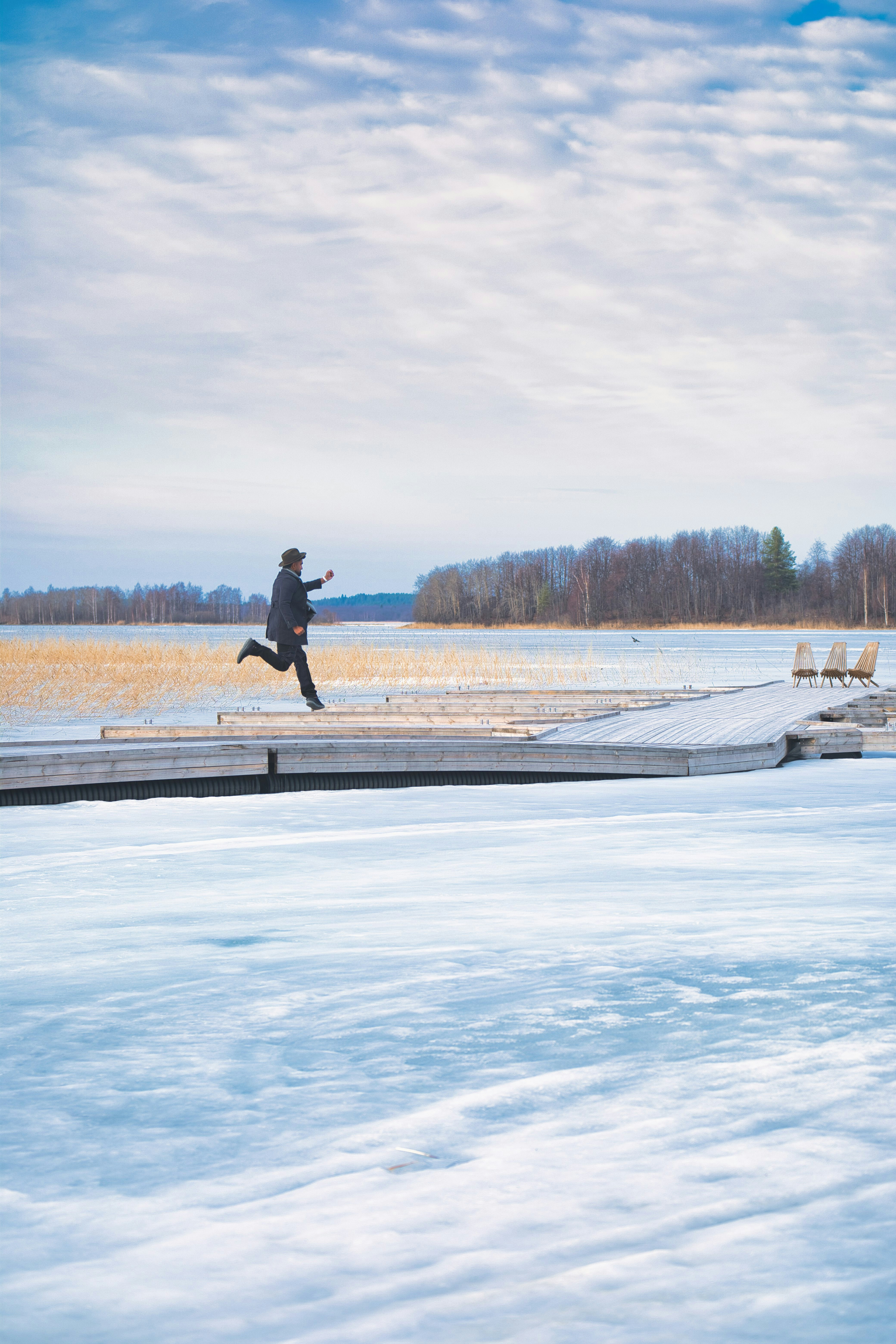 Runner in a Winter Boardwalk: A Quiet Dash Across Snow and Sky
