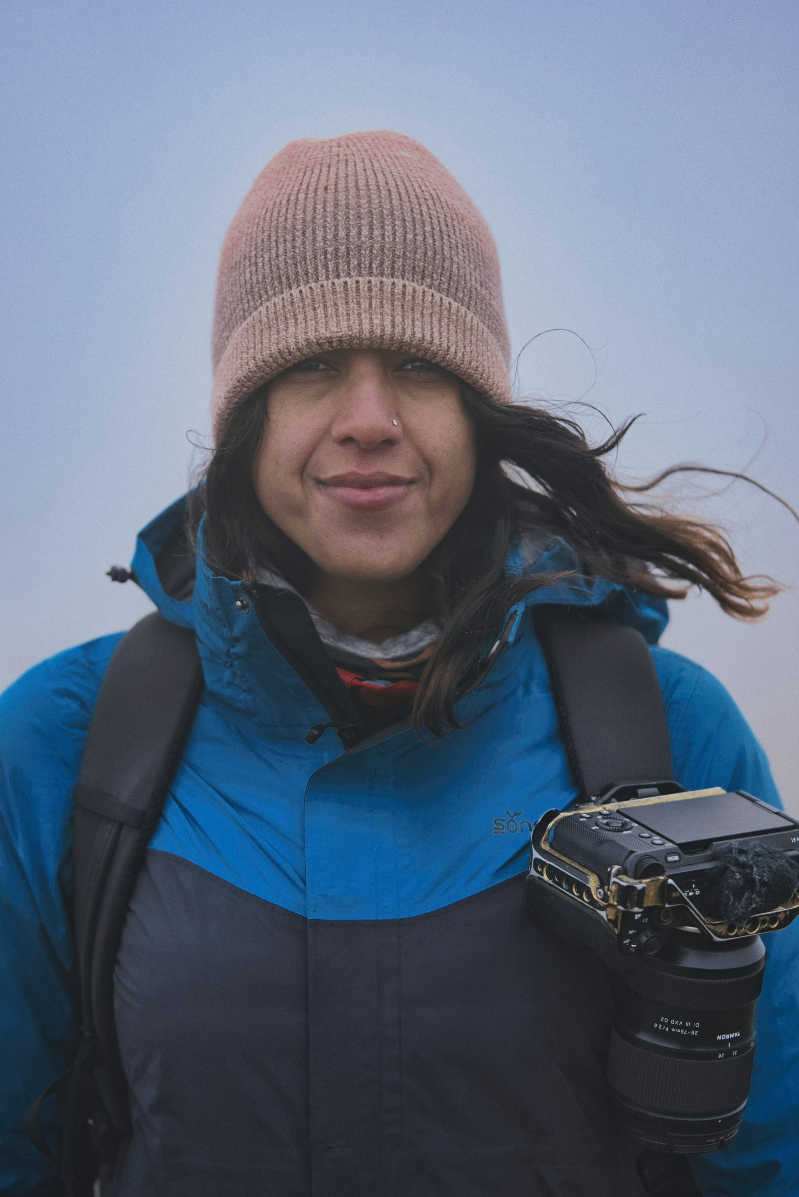 Windswept Portrait: A Mountain Explorer with a Vintage Camera