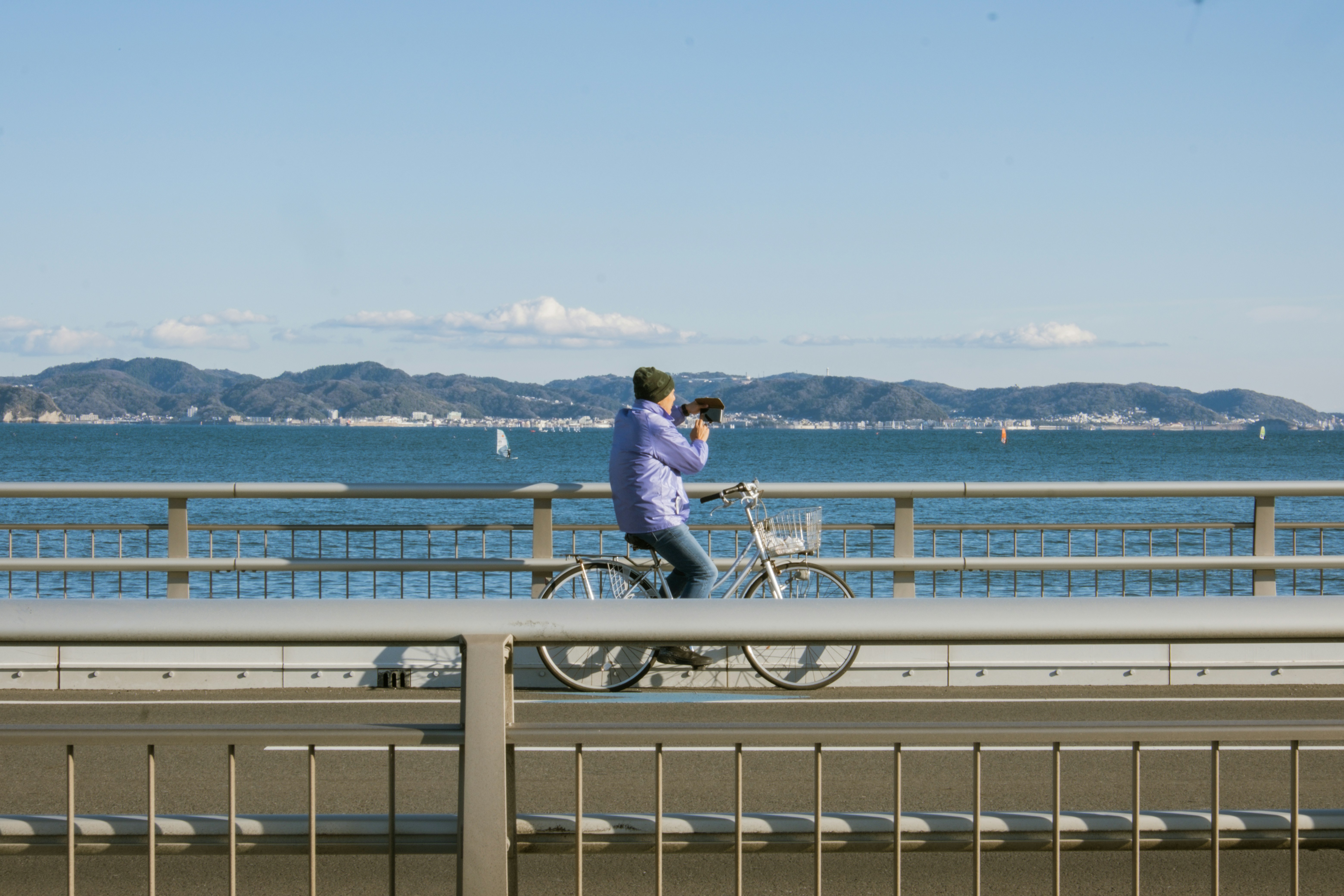 Cyclist with Camera: A Quiet Moment Along the Waterfront