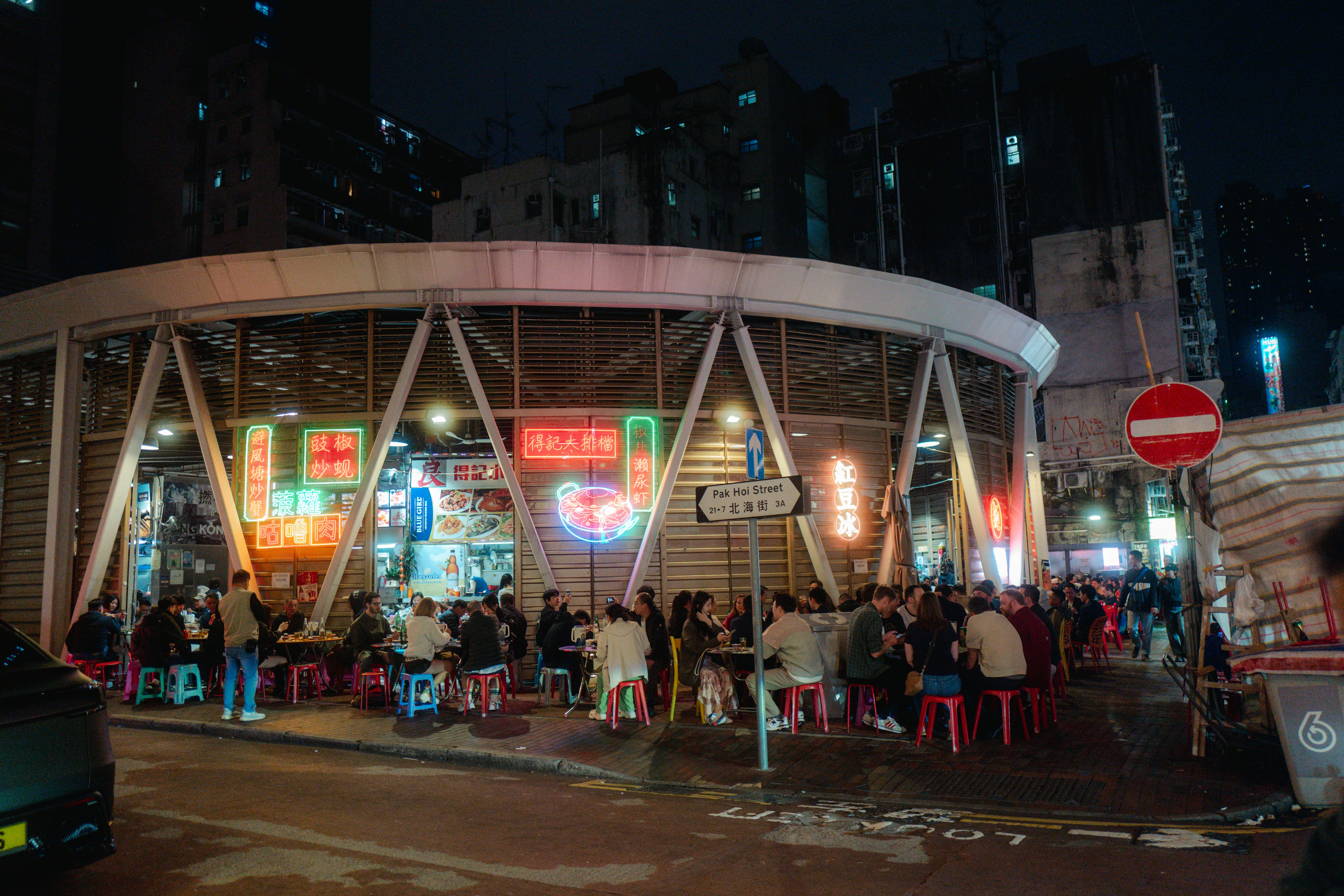 People dining outside a brightly lit building at night
