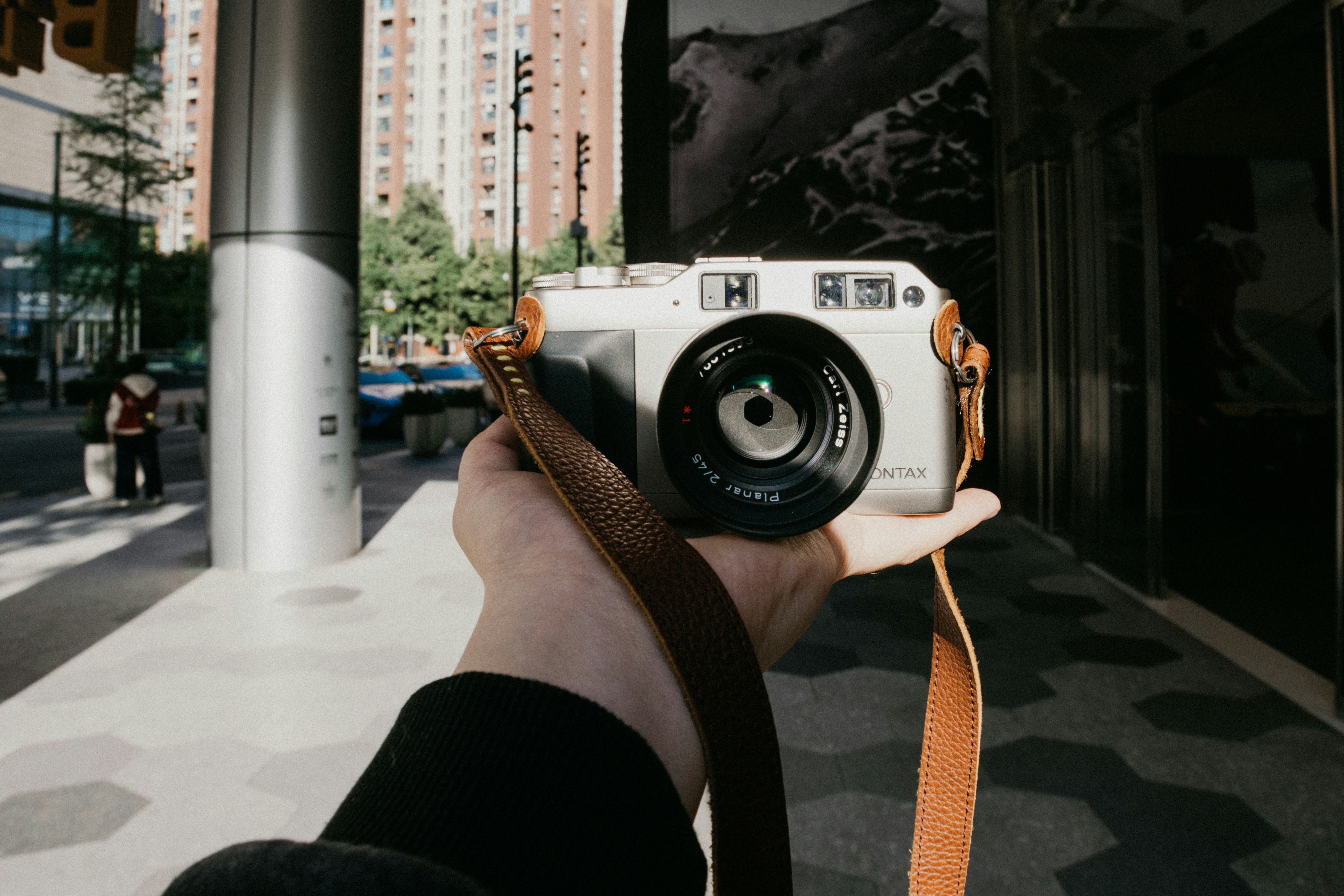 Retro-Roller: A White Pentax Mirror in Hand in an Urban Plaza