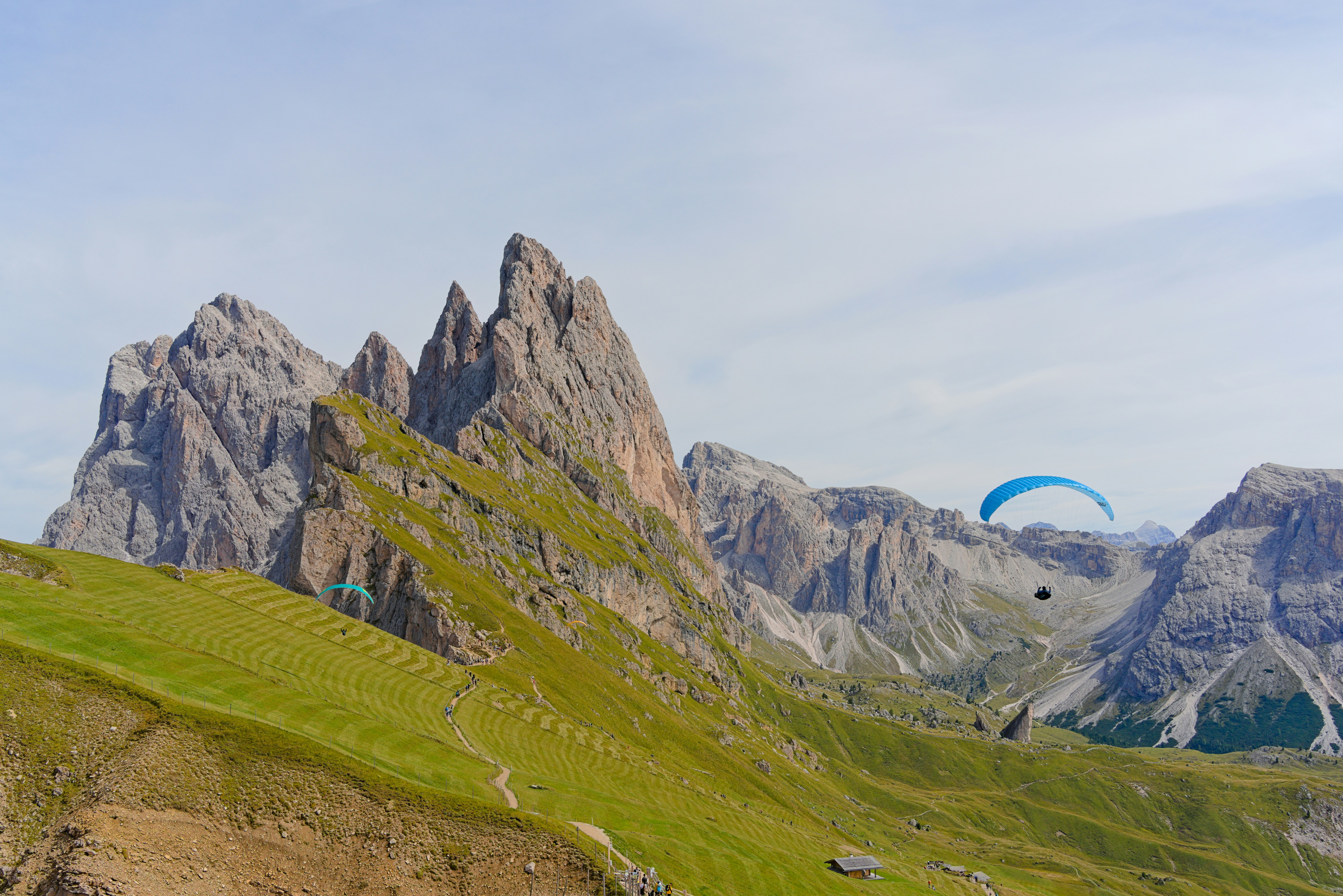 Rugged Dolomitic Peaks Under a Paragliding Arc