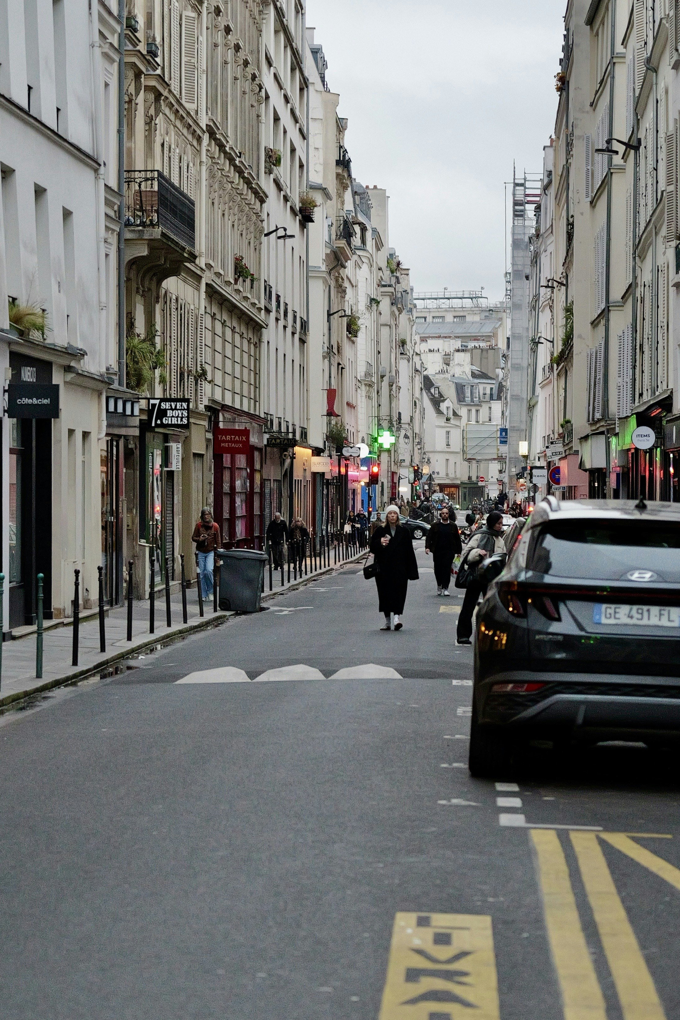 Parisian Street in Focus: Pedestrian Parade Under Pale Skies
