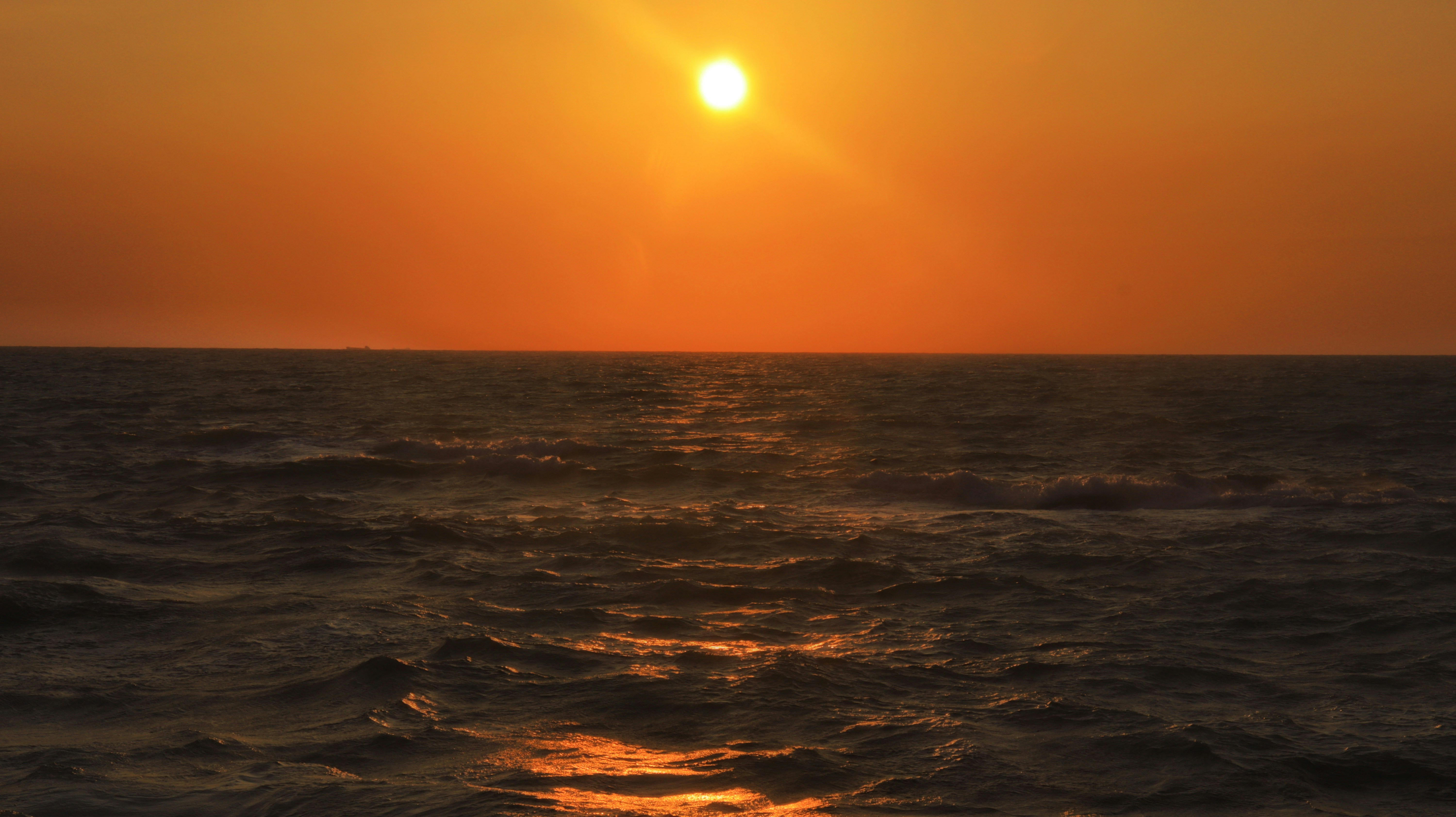 Golden Horizon: Sunlit Sea Beneath a Quiet Sky