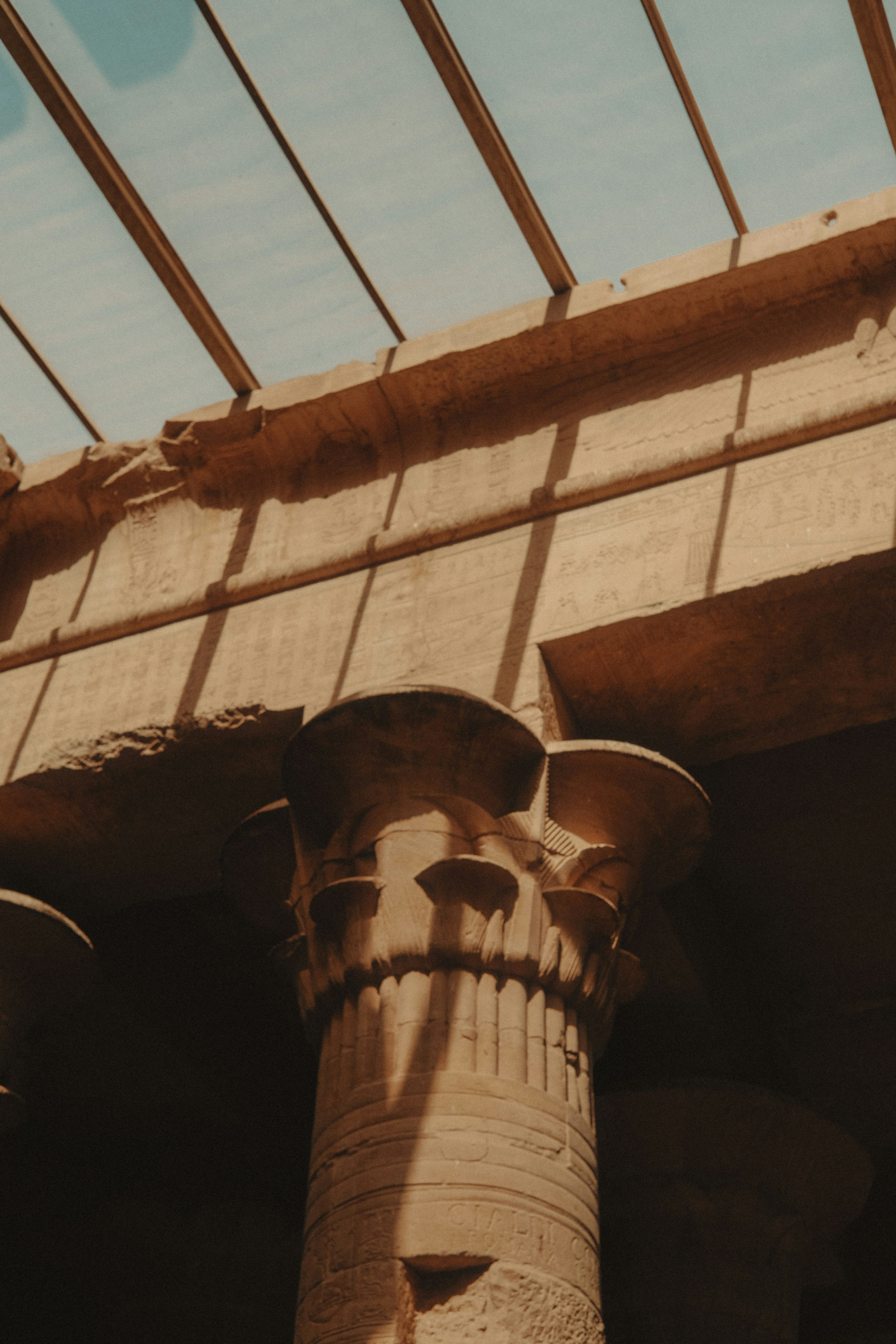 Corinthian Capital Framing: Sunlit Columns Beneath a Modern Glass Roof