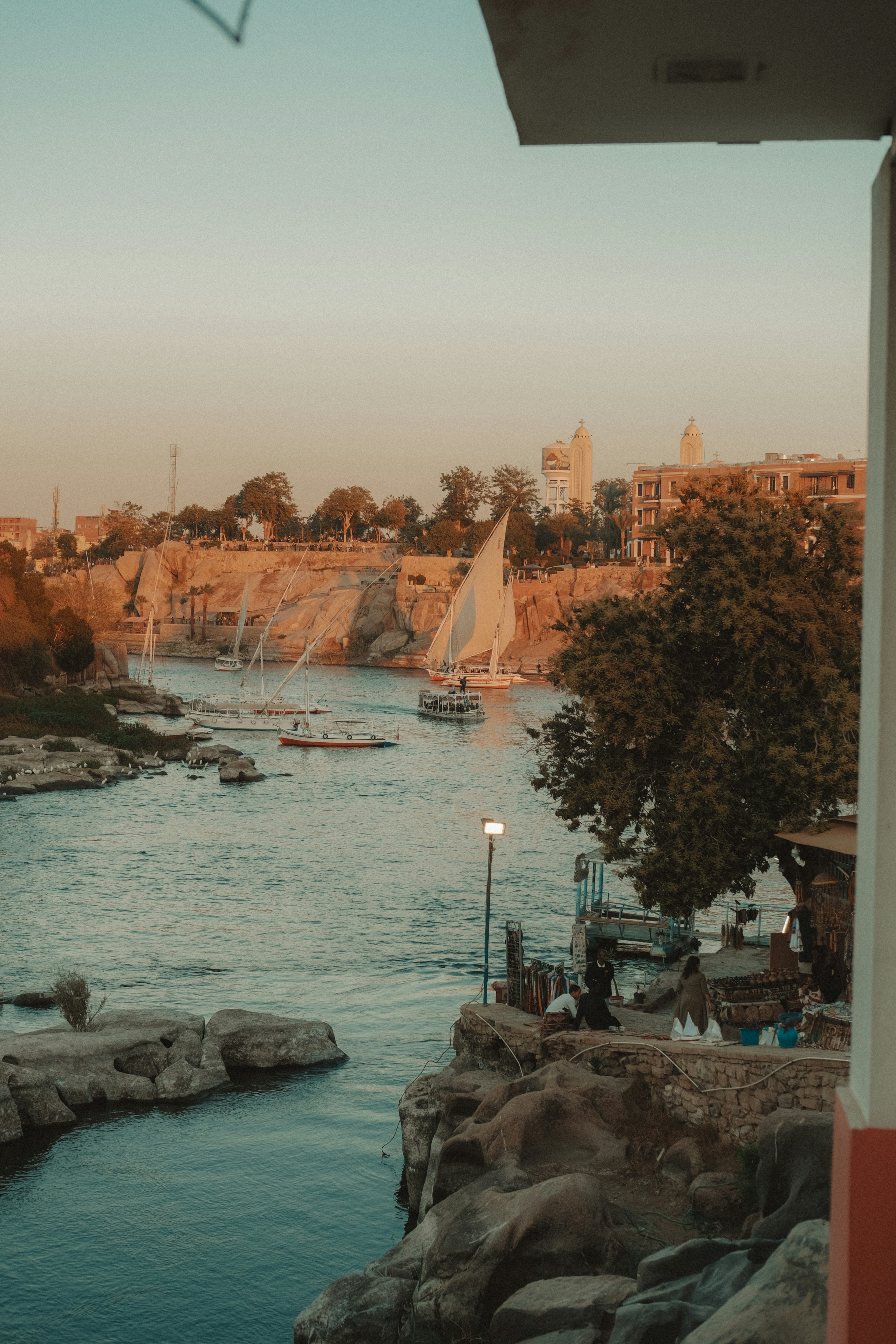 Sunlit harbor seen from a rocky seaside terrace at golden hour