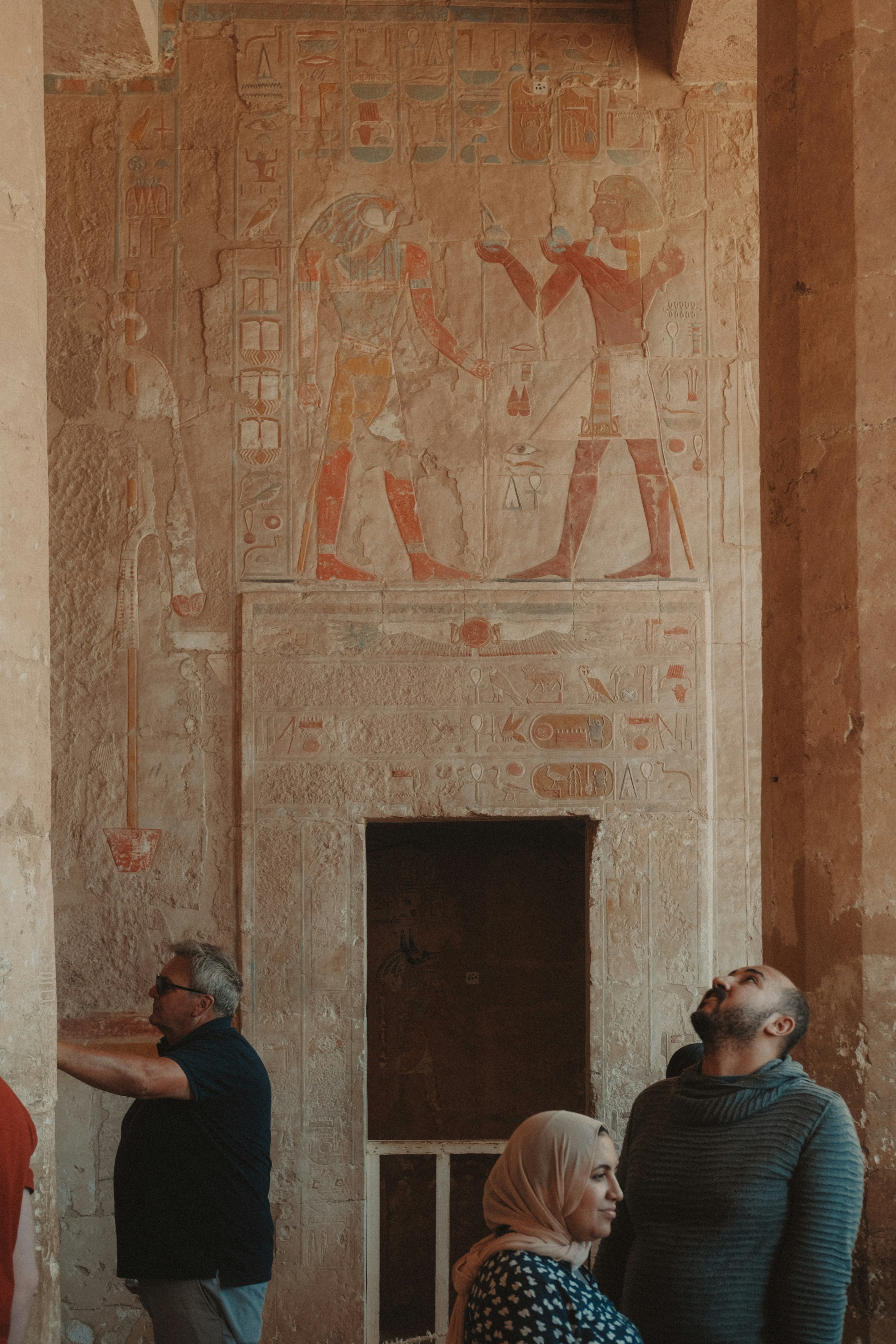 Hushed Gallery: Tourists Beneath Ancient Reliefs